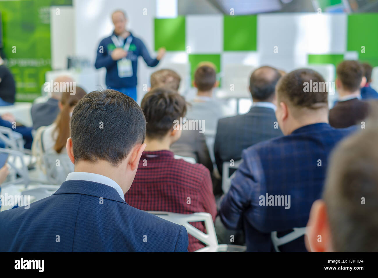 Audience listens to the lecturer at the business conference, back view ...