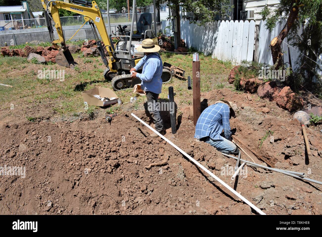 Moving rocks and installing piping for landscaping, by Mexican laborers ...