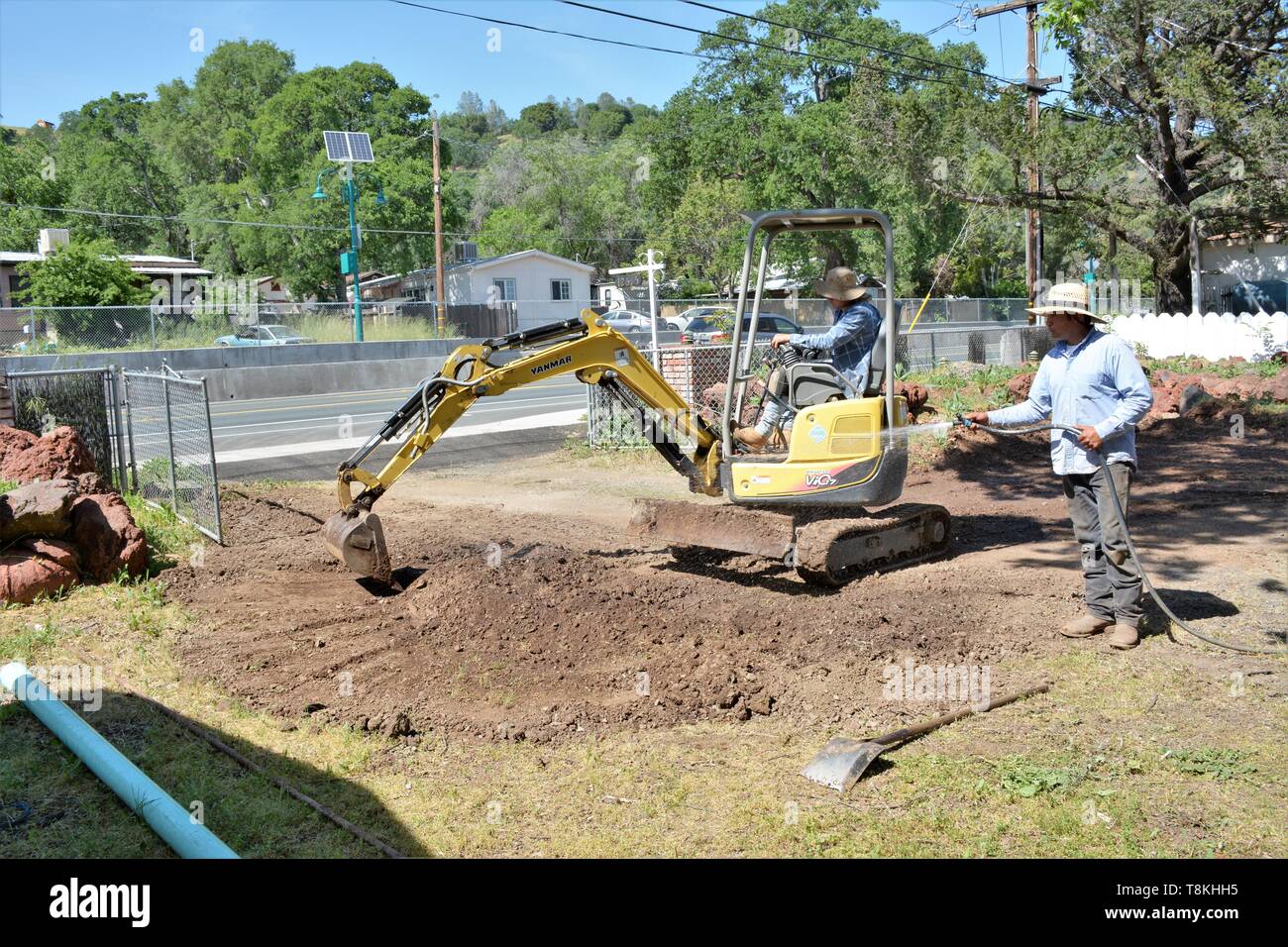 Moving rocks and installing piping for landscaping, by Mexican laborers ...