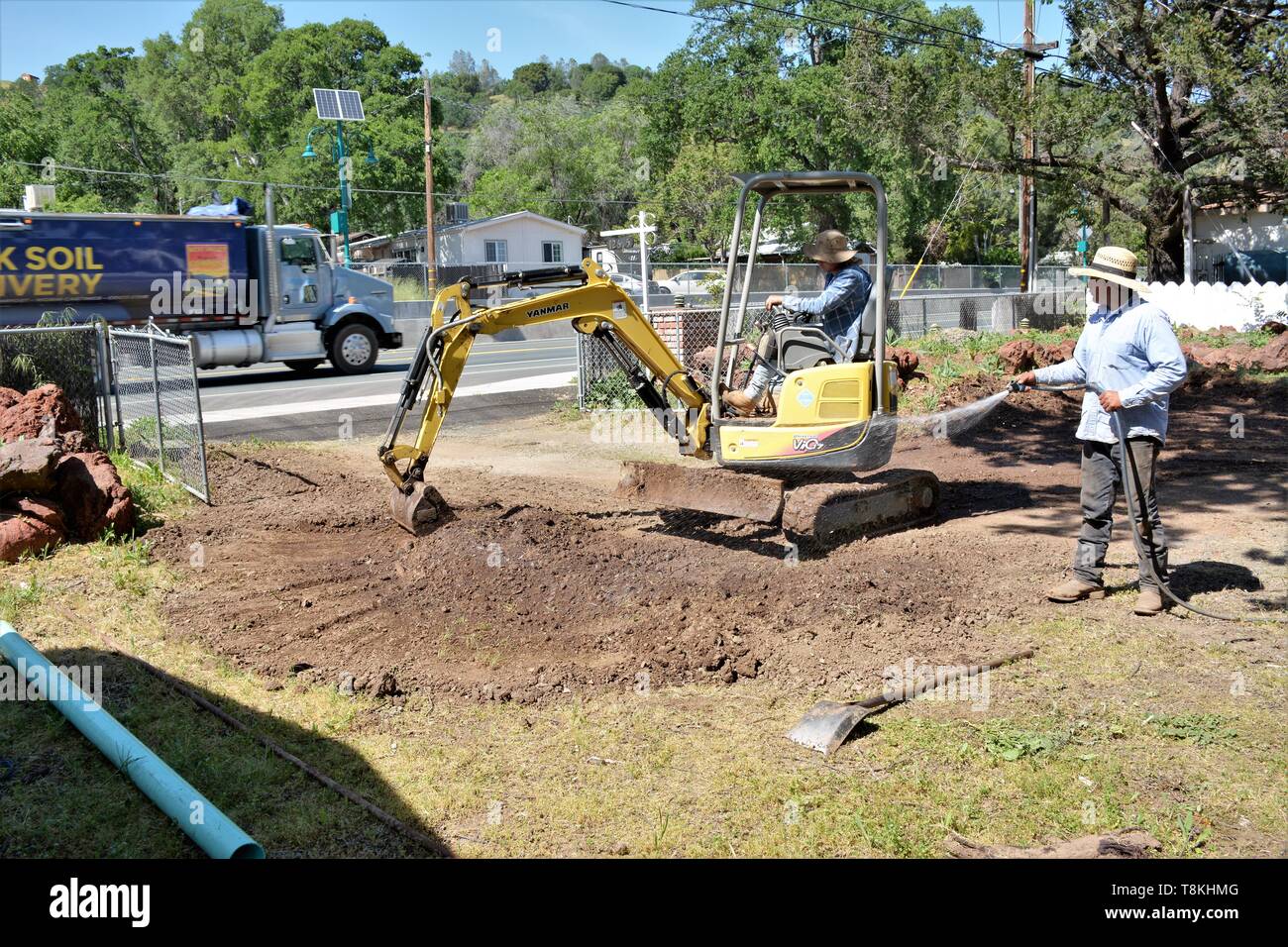 Moving rocks and installing piping for landscaping, by Mexican laborers ...
