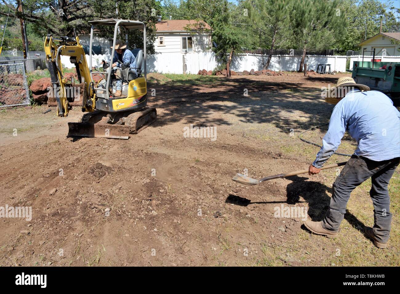 Moving rocks and installing piping for landscaping, by Mexican laborers ...