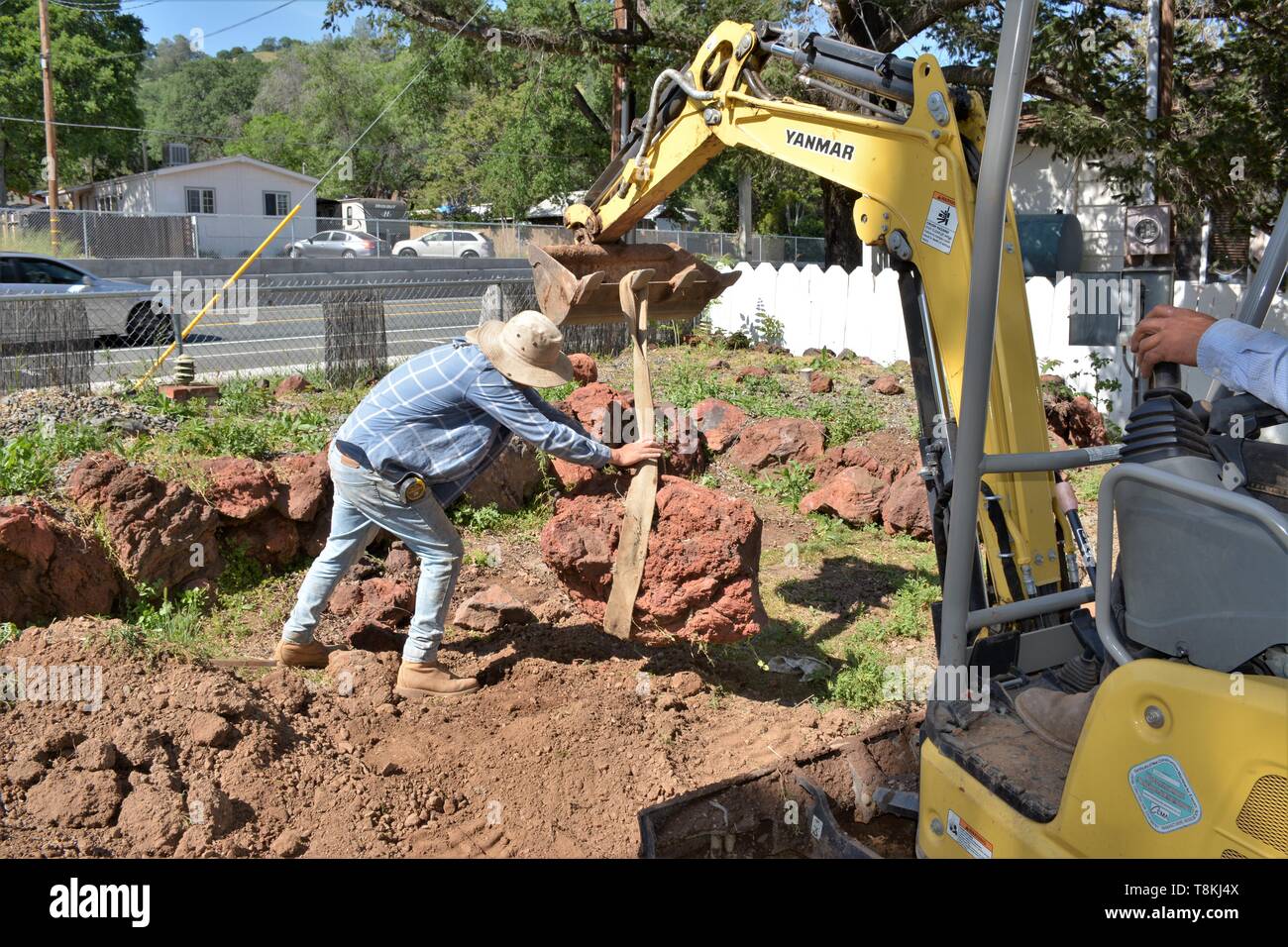 Moving rocks and installing piping for landscaping, by Mexican laborers ...