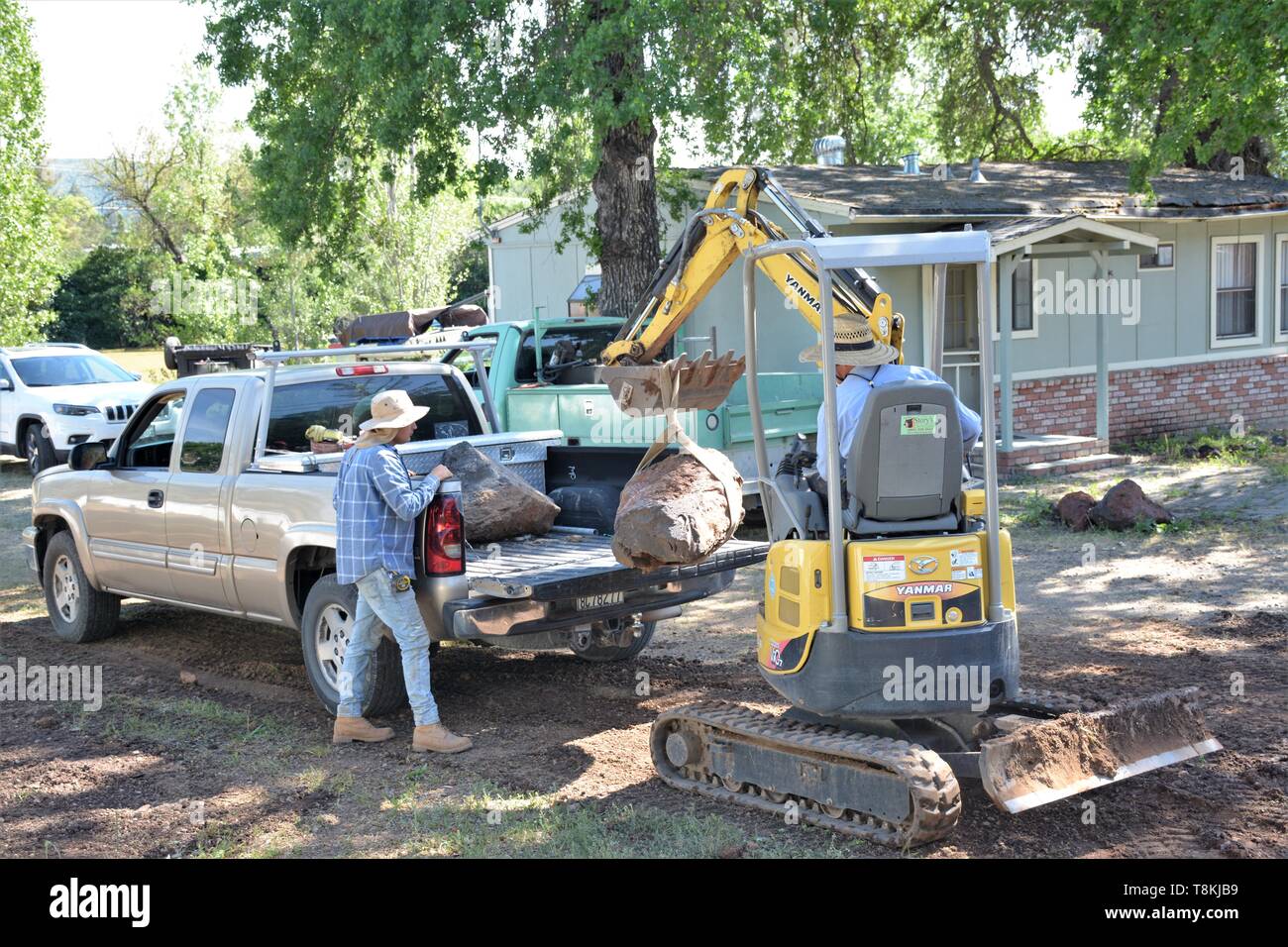 Moving rocks and installing piping for landscaping, by Mexican laborers ...
