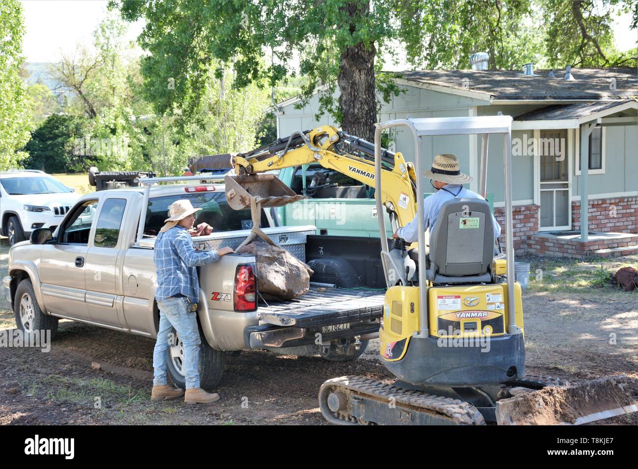 Moving rocks and installing piping for landscaping, by Mexican laborers ...