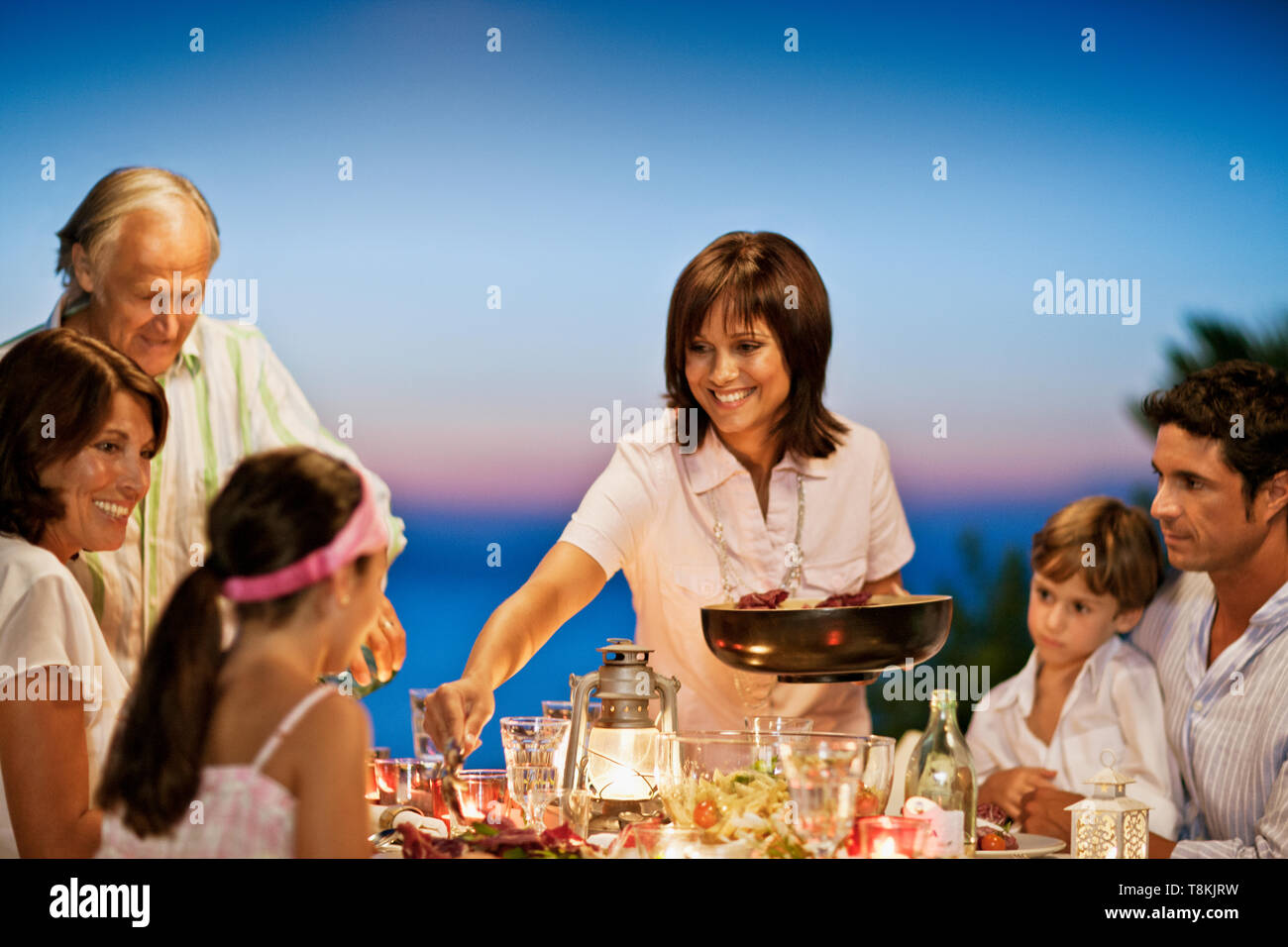 Family enjoying an outdoor dinner on their back deck Stock Photo - Alamy