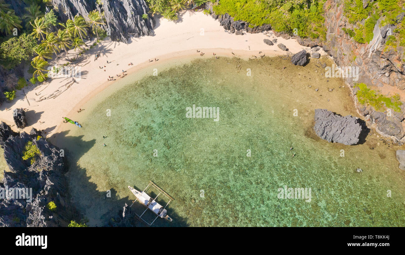 Beautiful lagoon surrounded by cliffs.Aerial drone view of swimmers ...