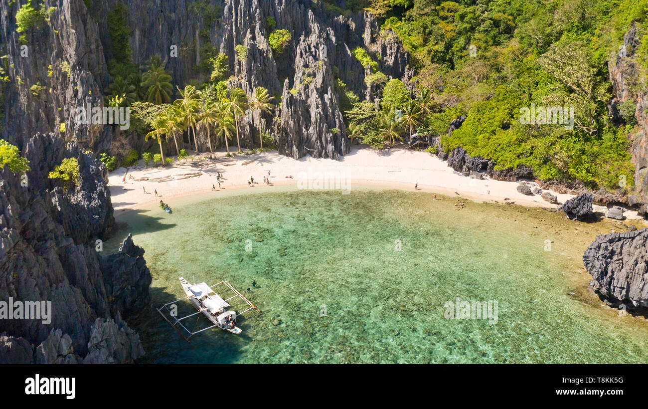 Beautiful lagoon surrounded by cliffs.Aerial drone view of swimmers ...