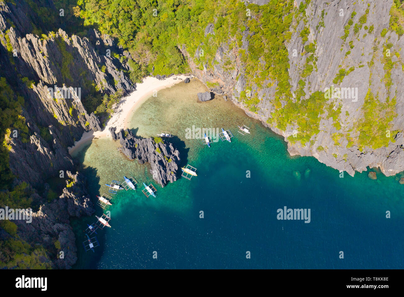 Beautiful lagoon surrounded by cliffs.Aerial drone view of swimmers ...