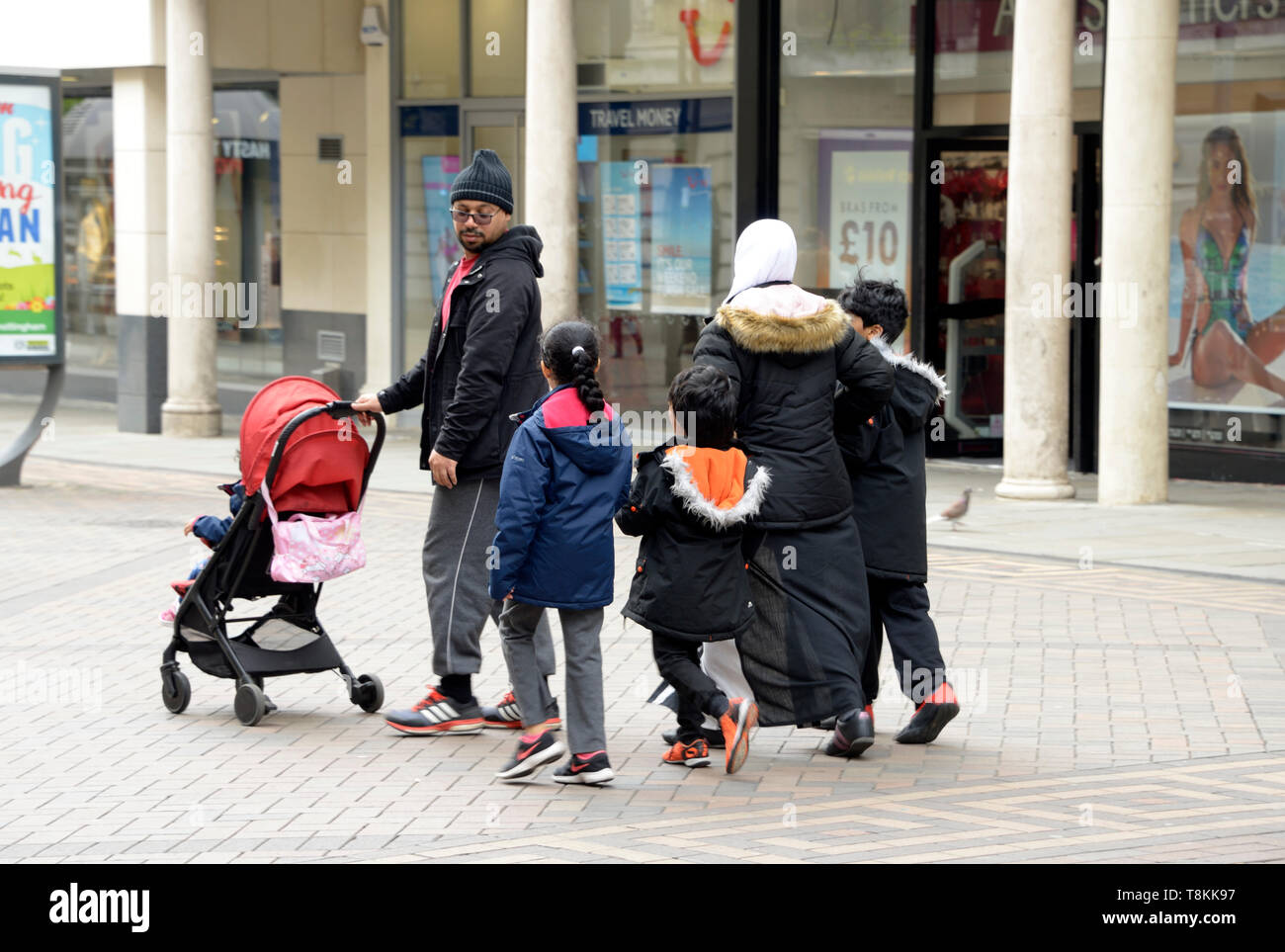 Muslim family out shopping, father looks round Stock Photo - Alamy
