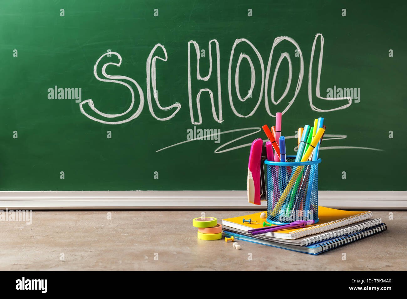 Table with stationery and word SCHOOL written on chalkboard Stock Photo ...
