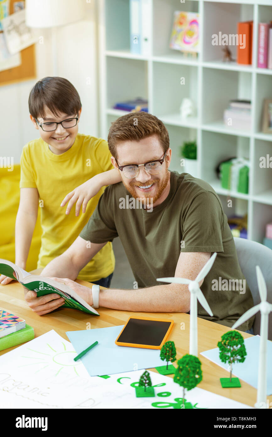 Smiling interested man in clear glasses carrying opened book Stock ...