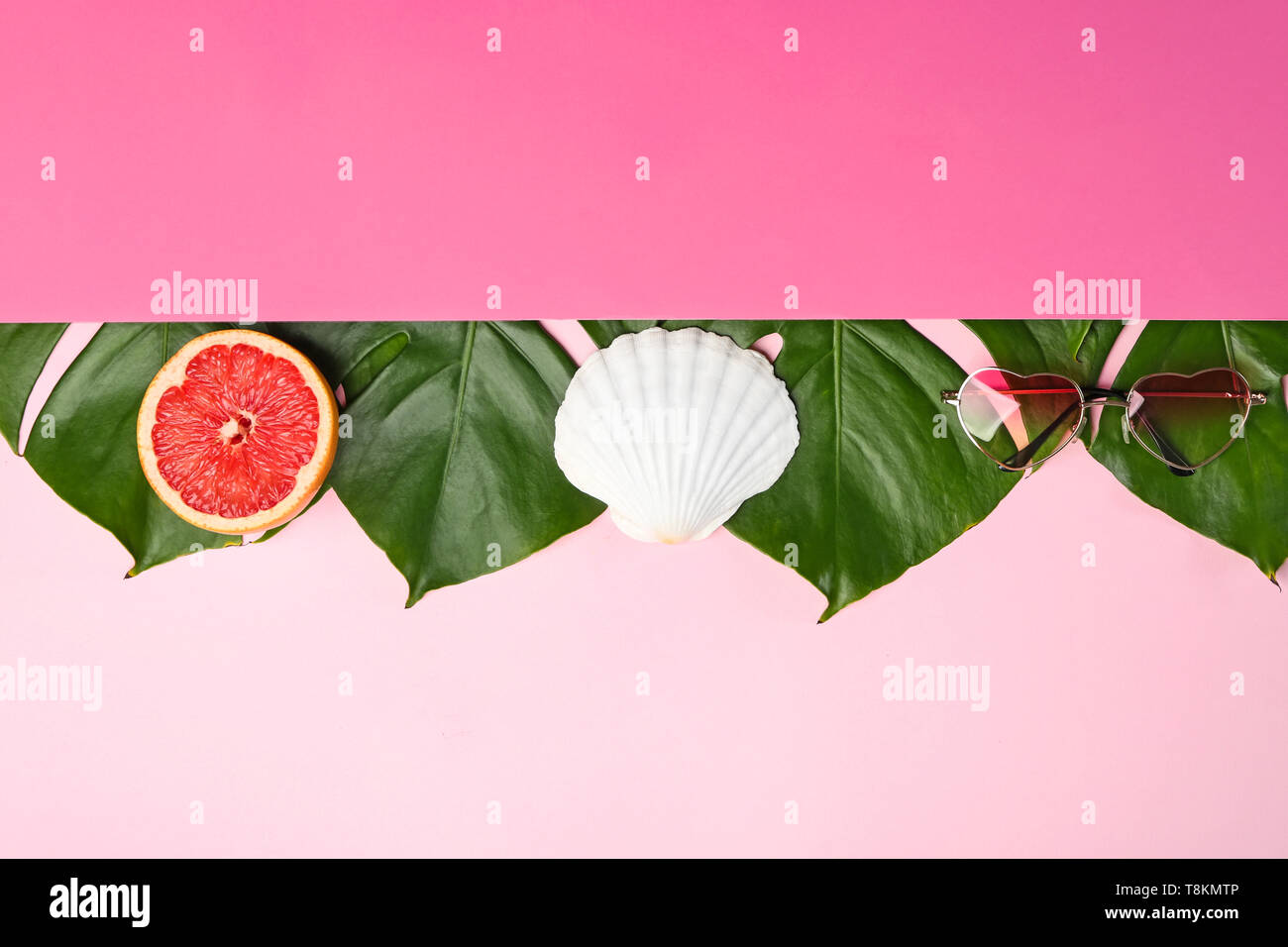 Summer composition with fresh monstera leaves, fruit, shell and card on ...