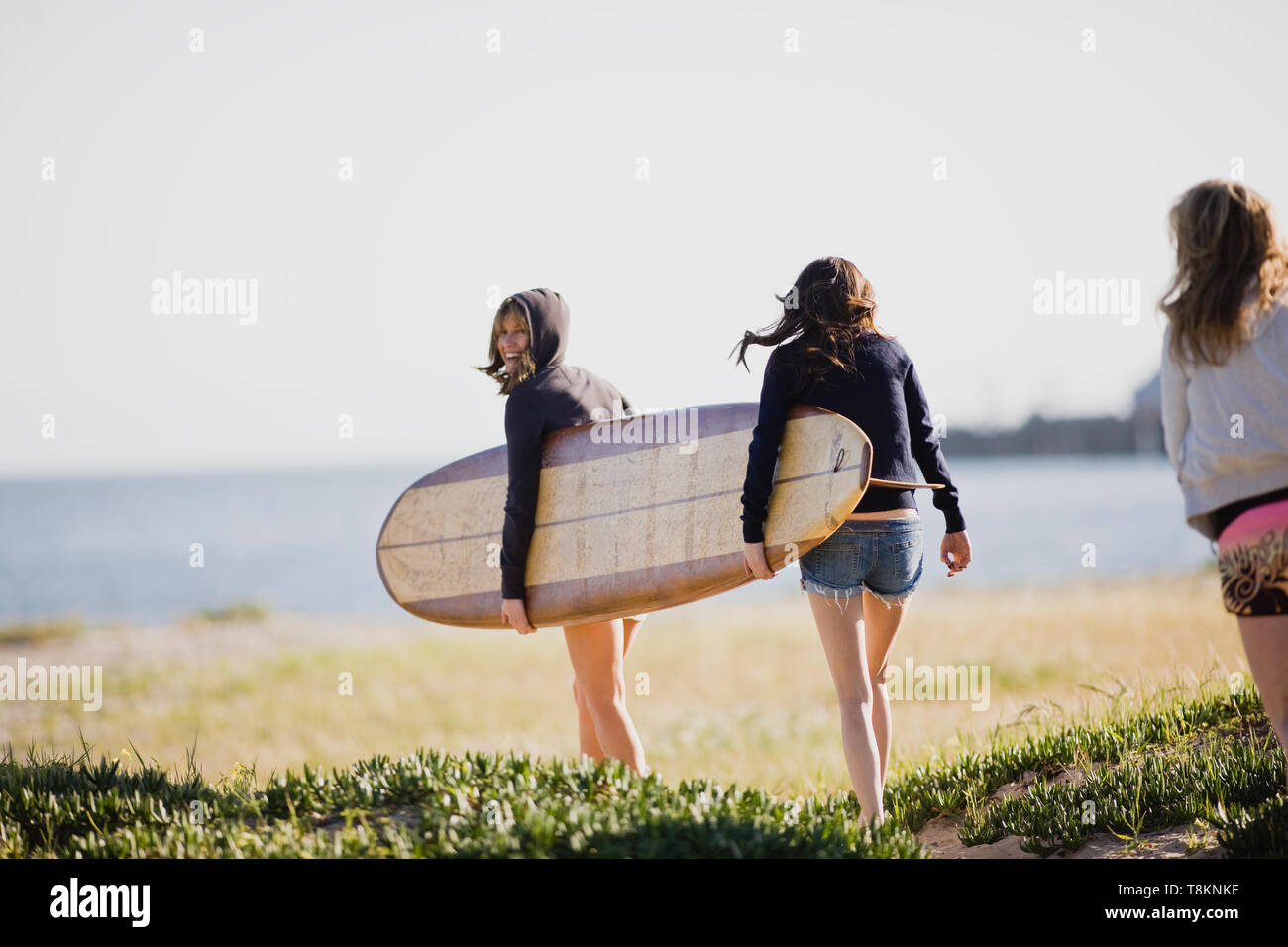 Woman walking shoreline carrying surfboard hi-res stock photography and ...
