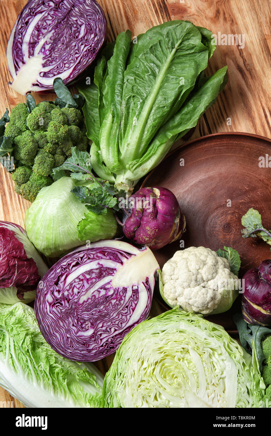 Different types of cabbage on wooden background Stock Photo - Alamy