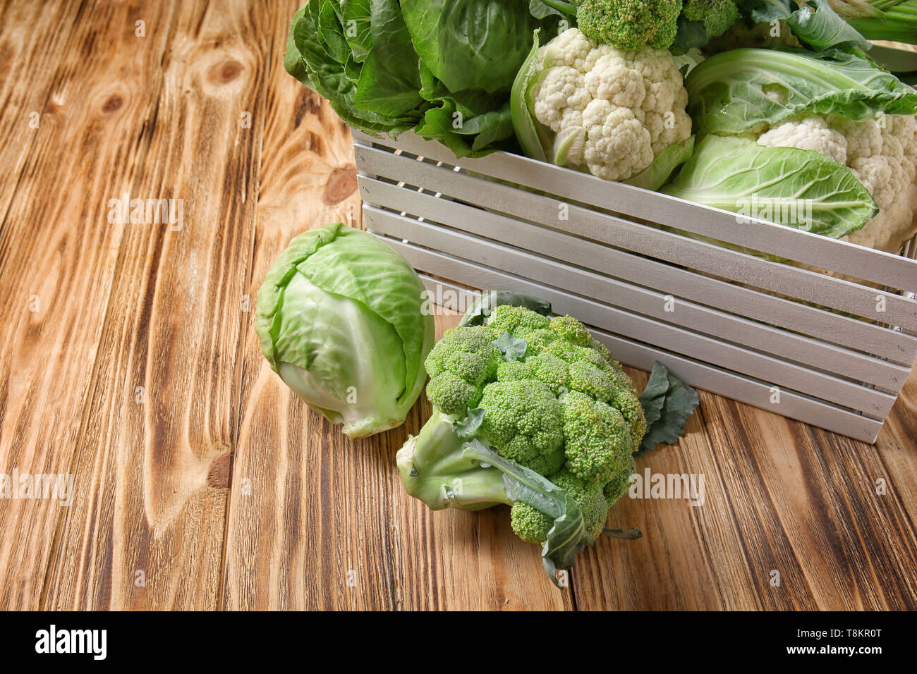 Crate with different types of cabbage on wooden background Stock Photo ...
