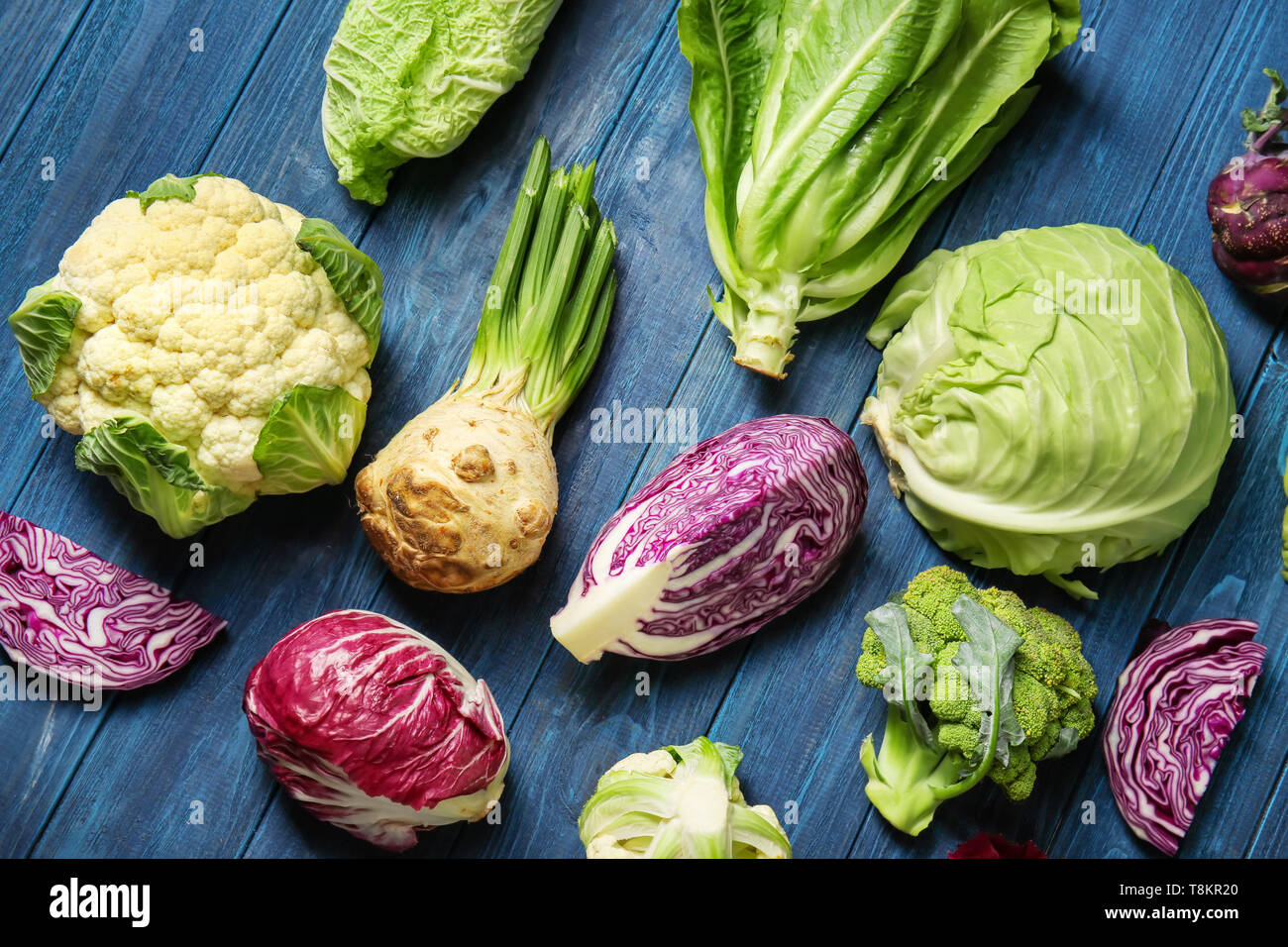 Different types of cabbage on color wooden background Stock Photo - Alamy