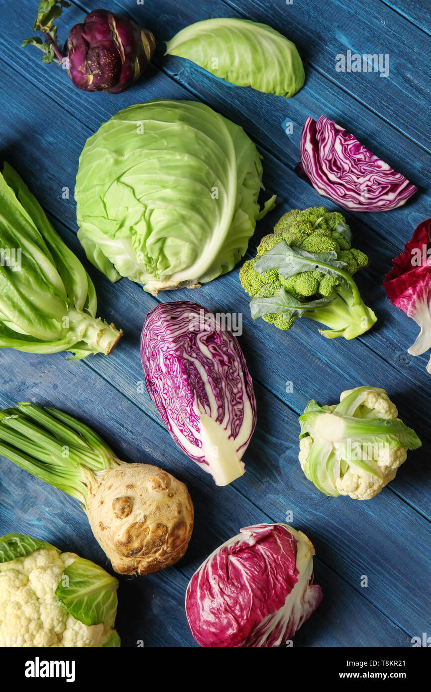 Different types of cabbage on color wooden background Stock Photo - Alamy