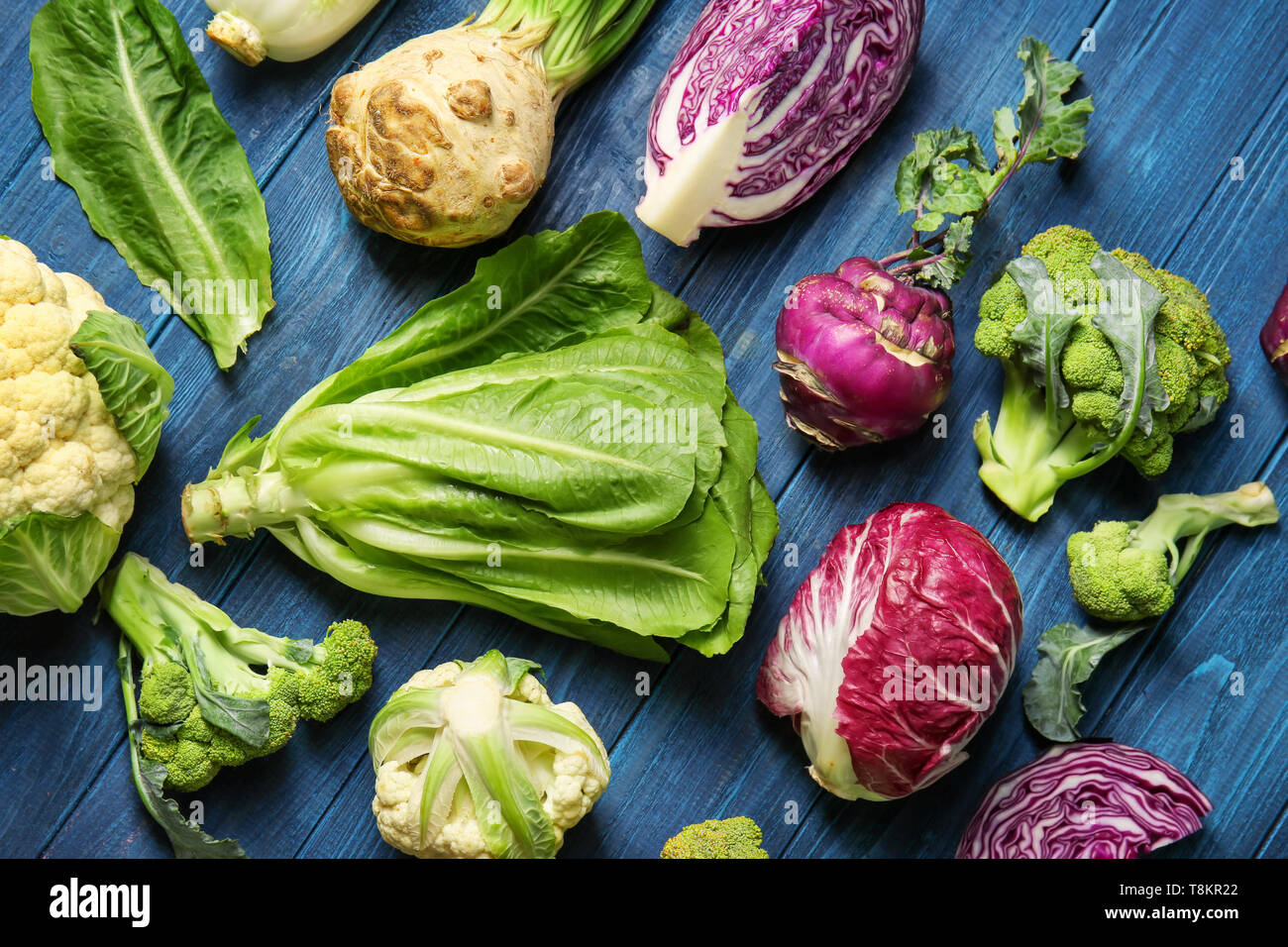 Different types of cabbage on color wooden background Stock Photo - Alamy