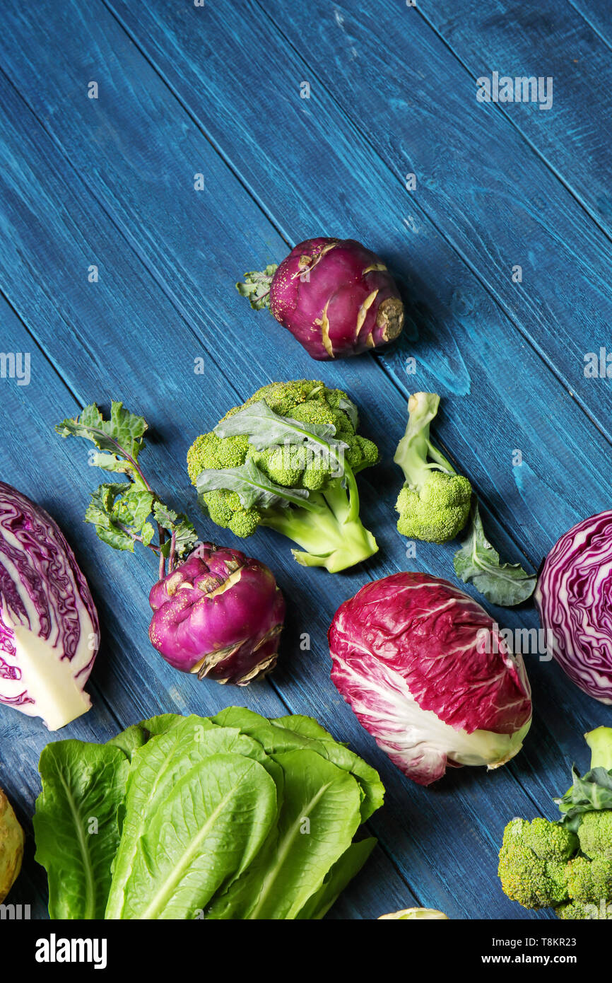 Different types of cabbage on color wooden background Stock Photo - Alamy