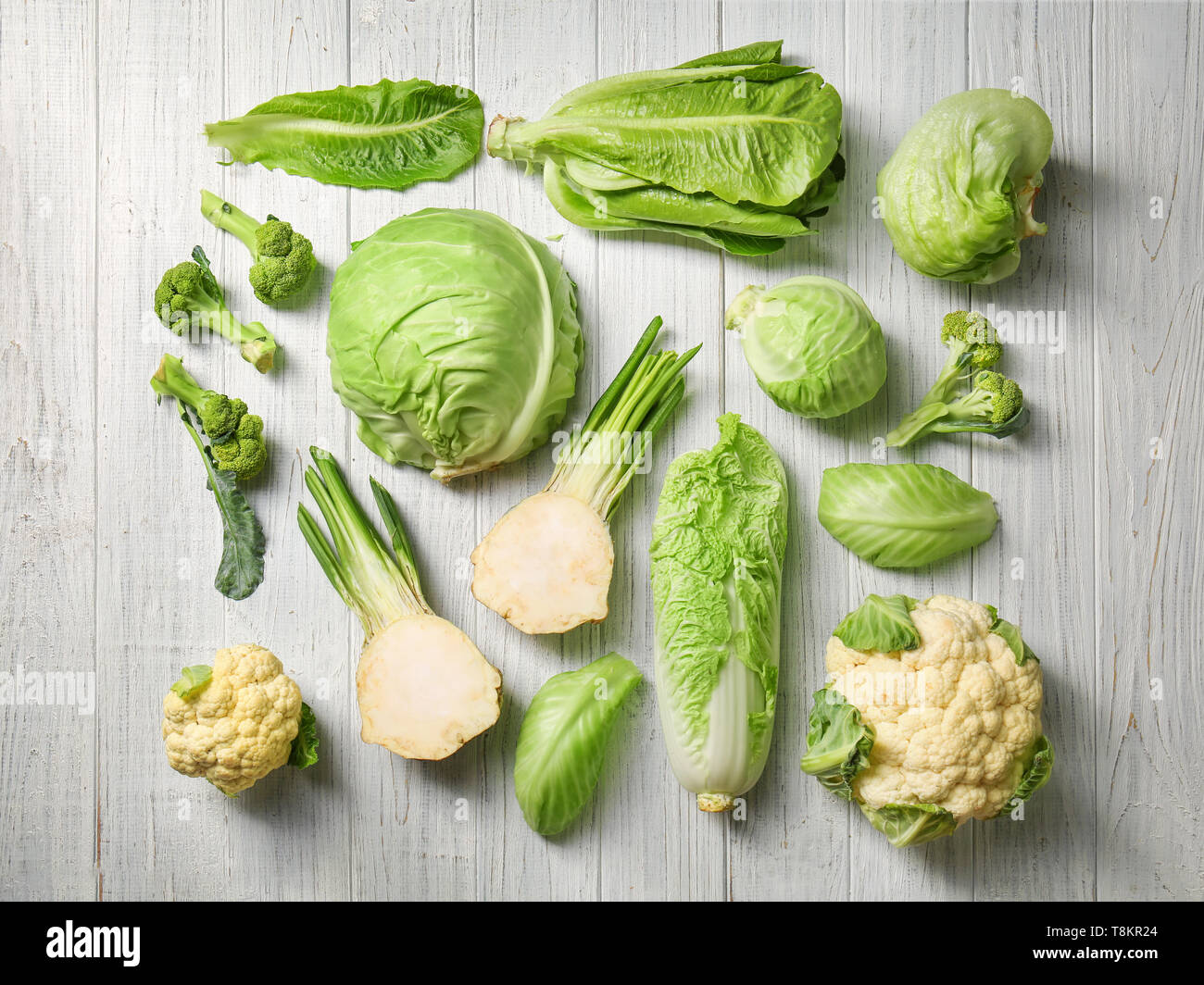 Different types of cabbage on light wooden background Stock Photo - Alamy