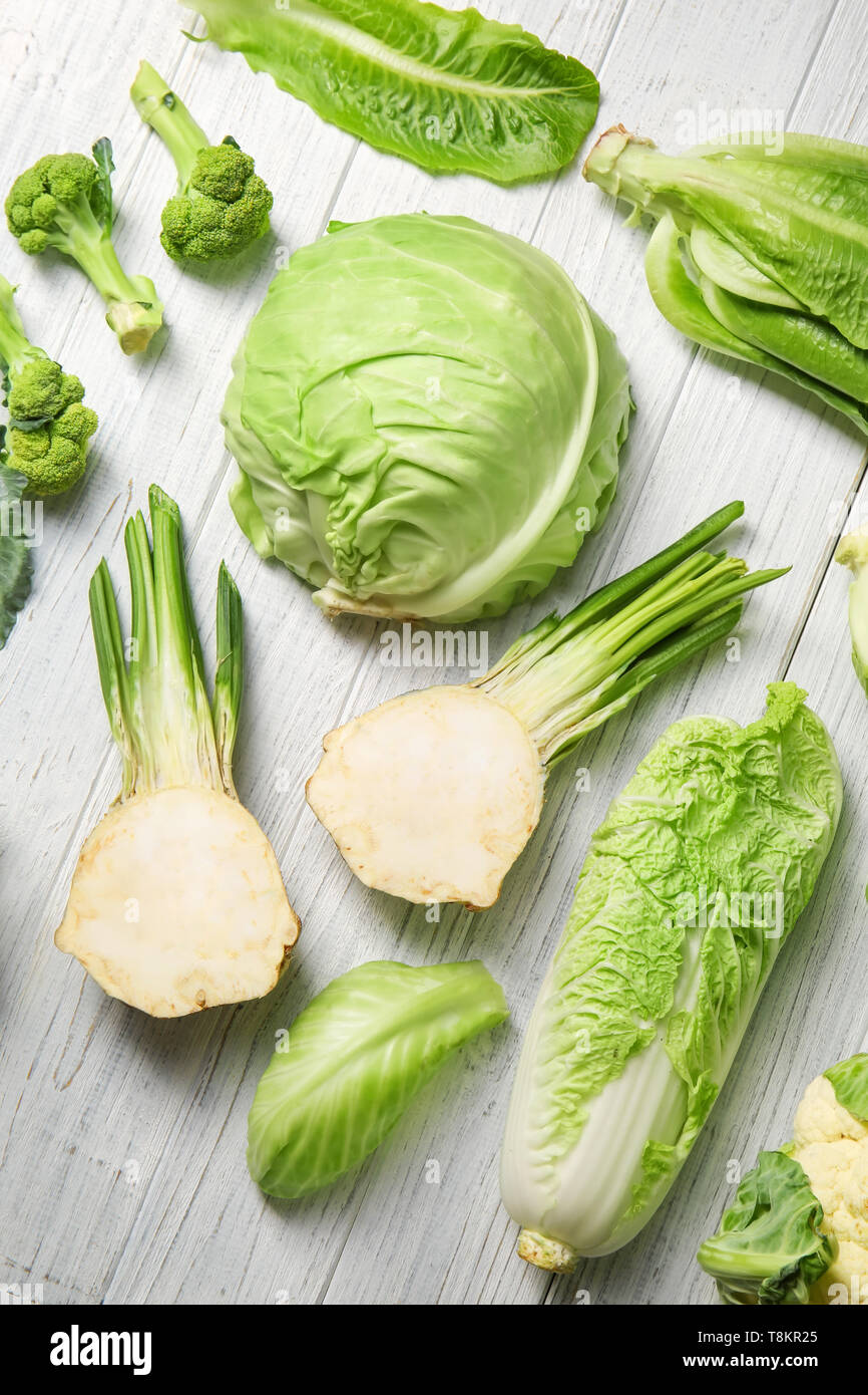 Different types of cabbage on light wooden background Stock Photo - Alamy