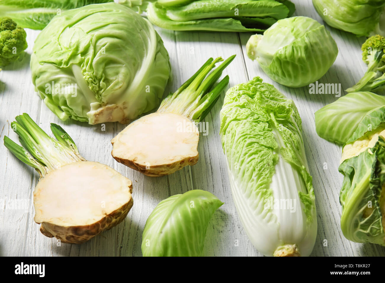 Different types of cabbage on light wooden background Stock Photo - Alamy
