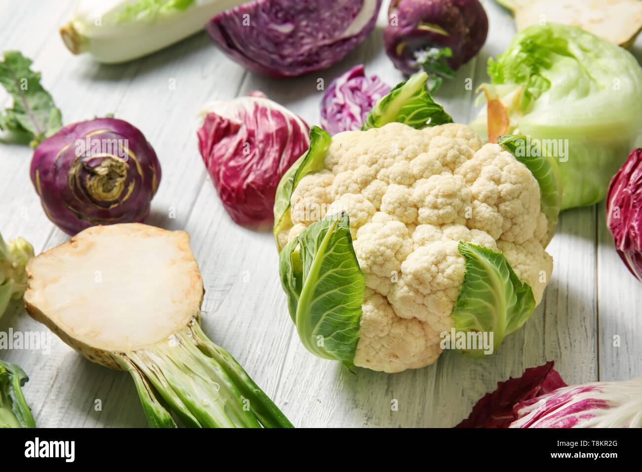 Different types of cabbage on light wooden background Stock Photo - Alamy