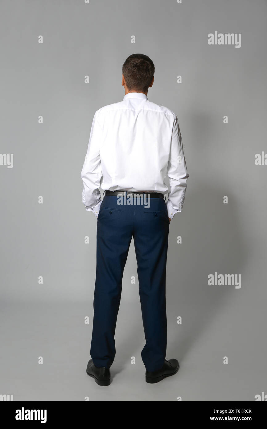 Man in formal clothes on grey background, back view Stock Photo - Alamy