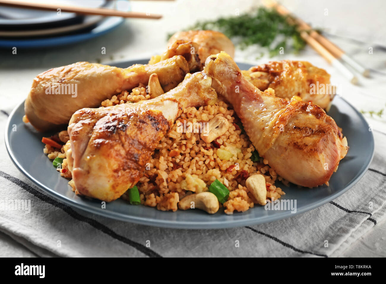 Plate with boiled rice, chicken legs and vegetables on table Stock ...