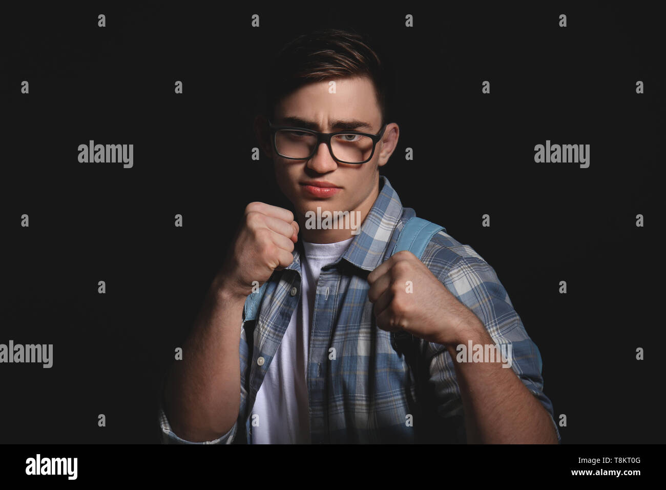 Bully teenage boy on dark background Stock Photo - Alamy