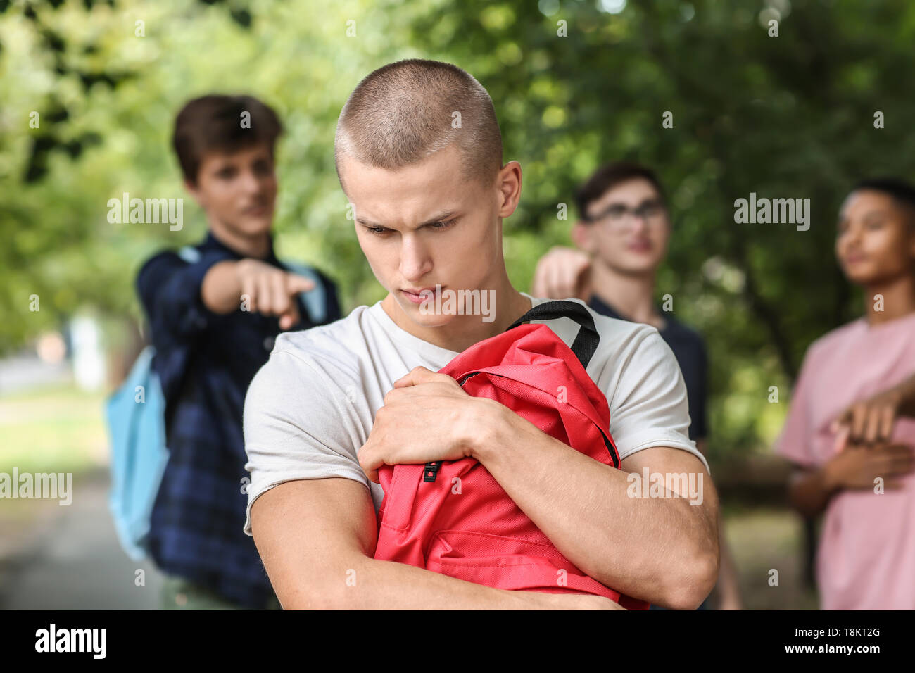 Bullied teenage boy with aggressive schoolmates outdoors Stock Photo ...