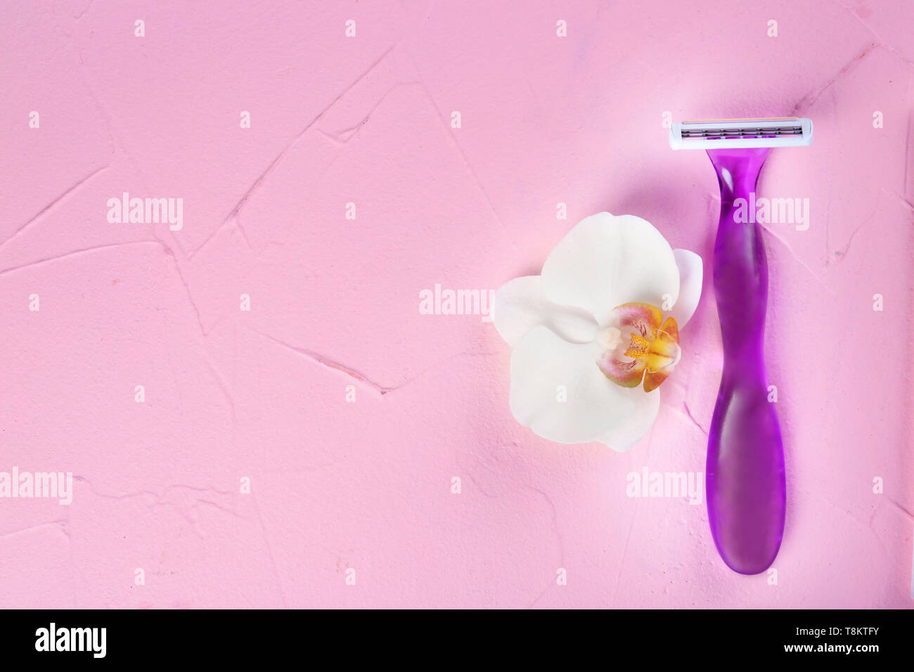 Safety razor with flower on color background Stock Photo - Alamy