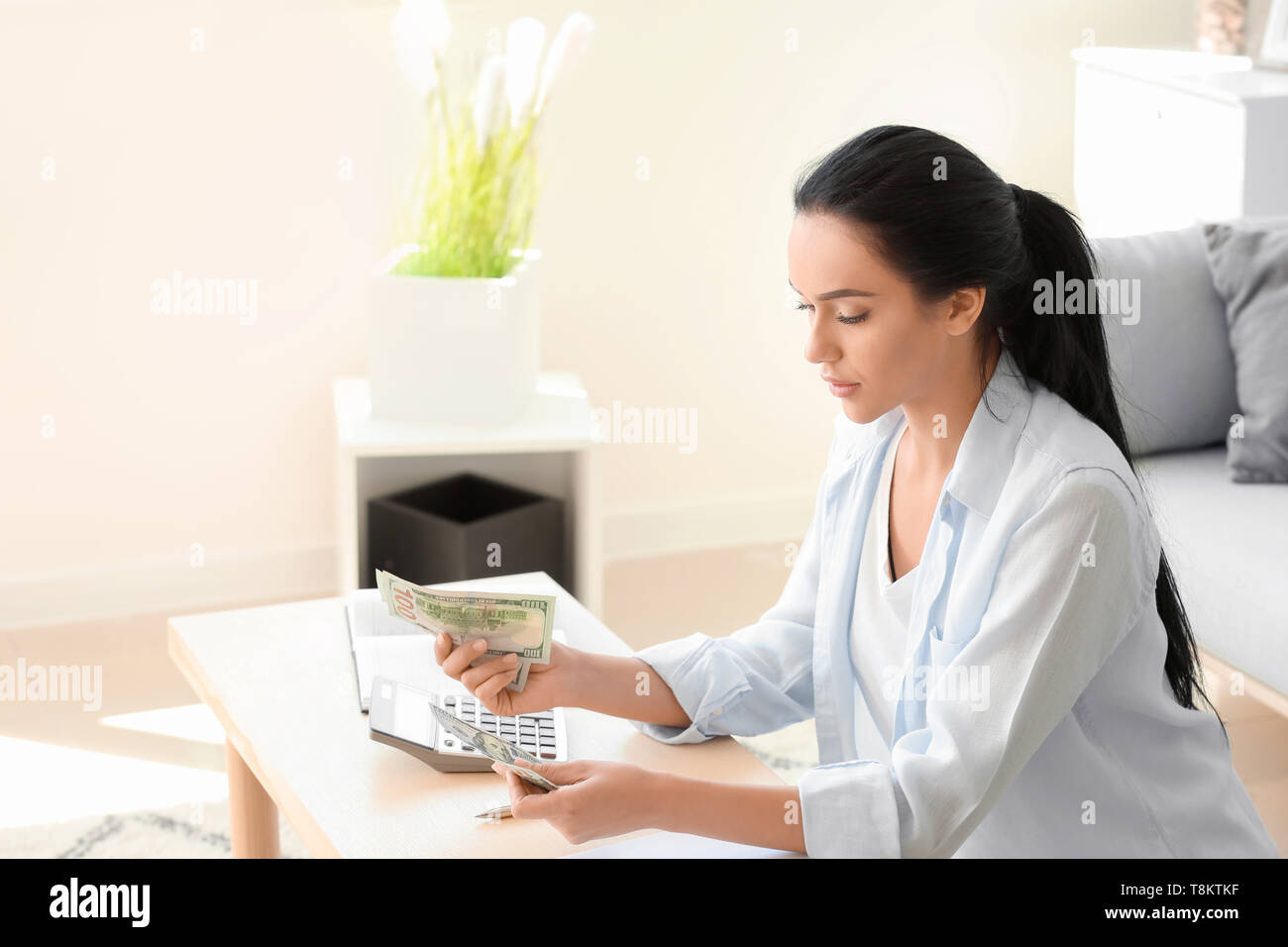 Young woman counting money at table Stock Photo - Alamy