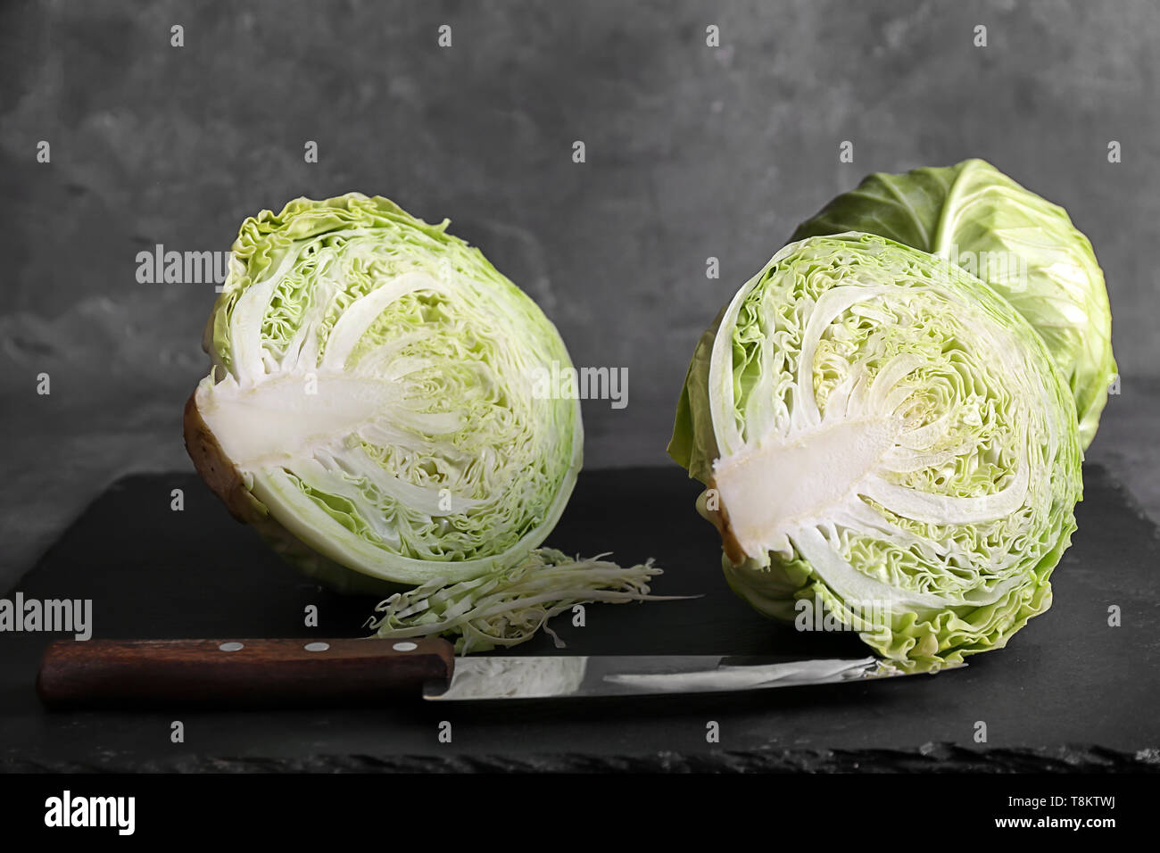 Cut fresh cabbage with knife on slate plate Stock Photo - Alamy