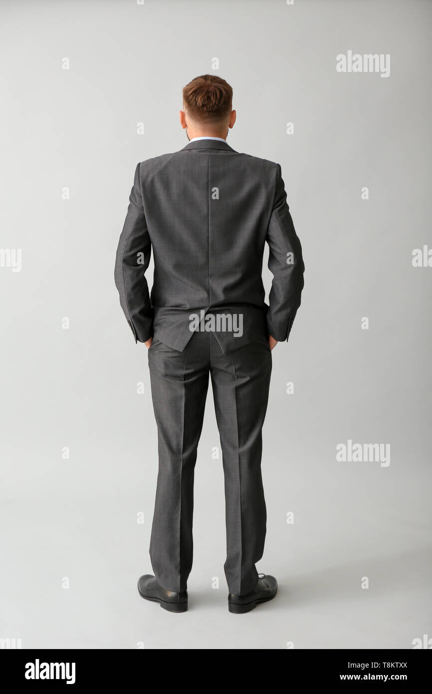 Man in formal clothes on grey background, back view Stock Photo - Alamy