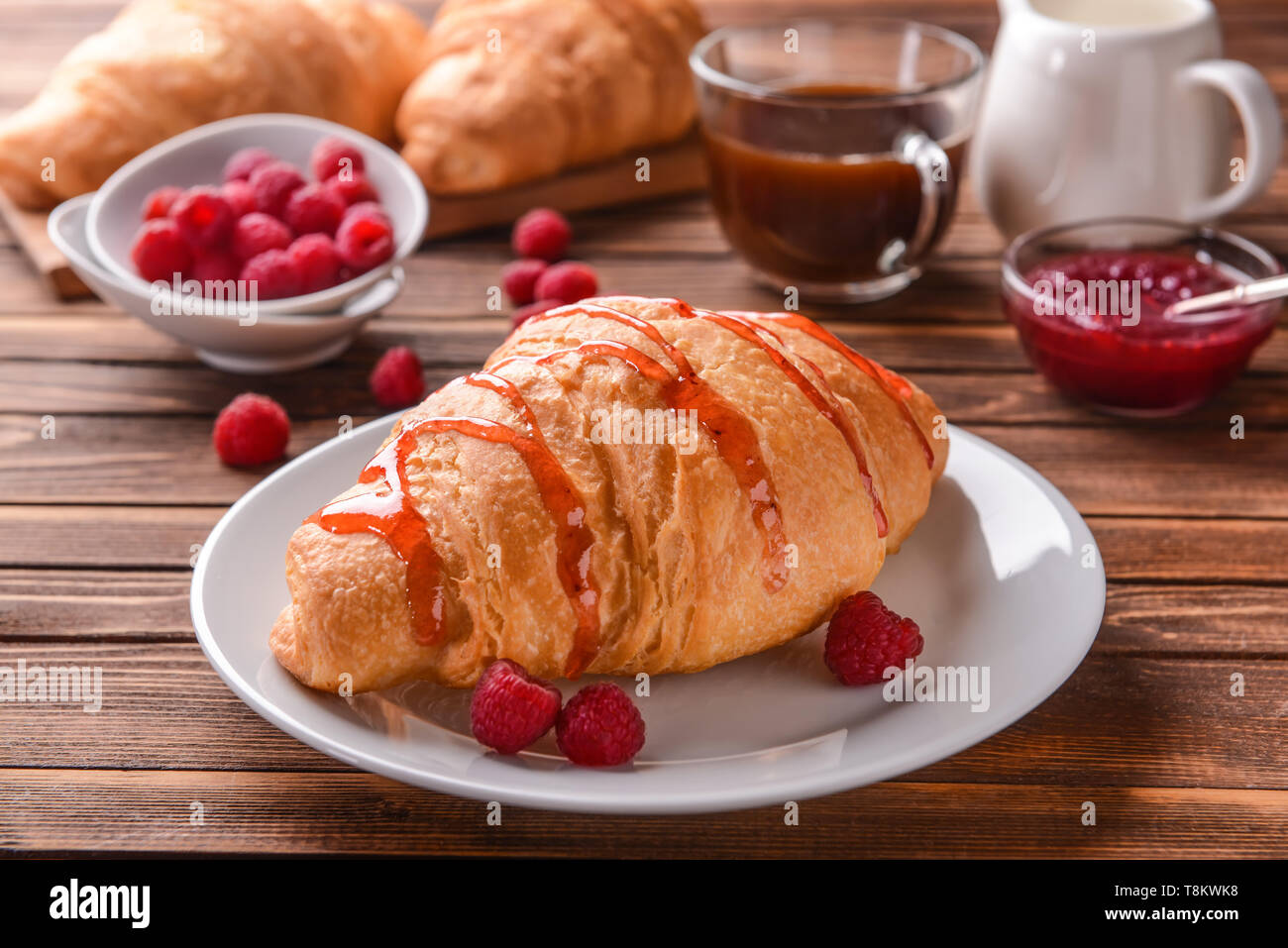 Tasty croissant with raspberry jam on plate Stock Photo - Alamy