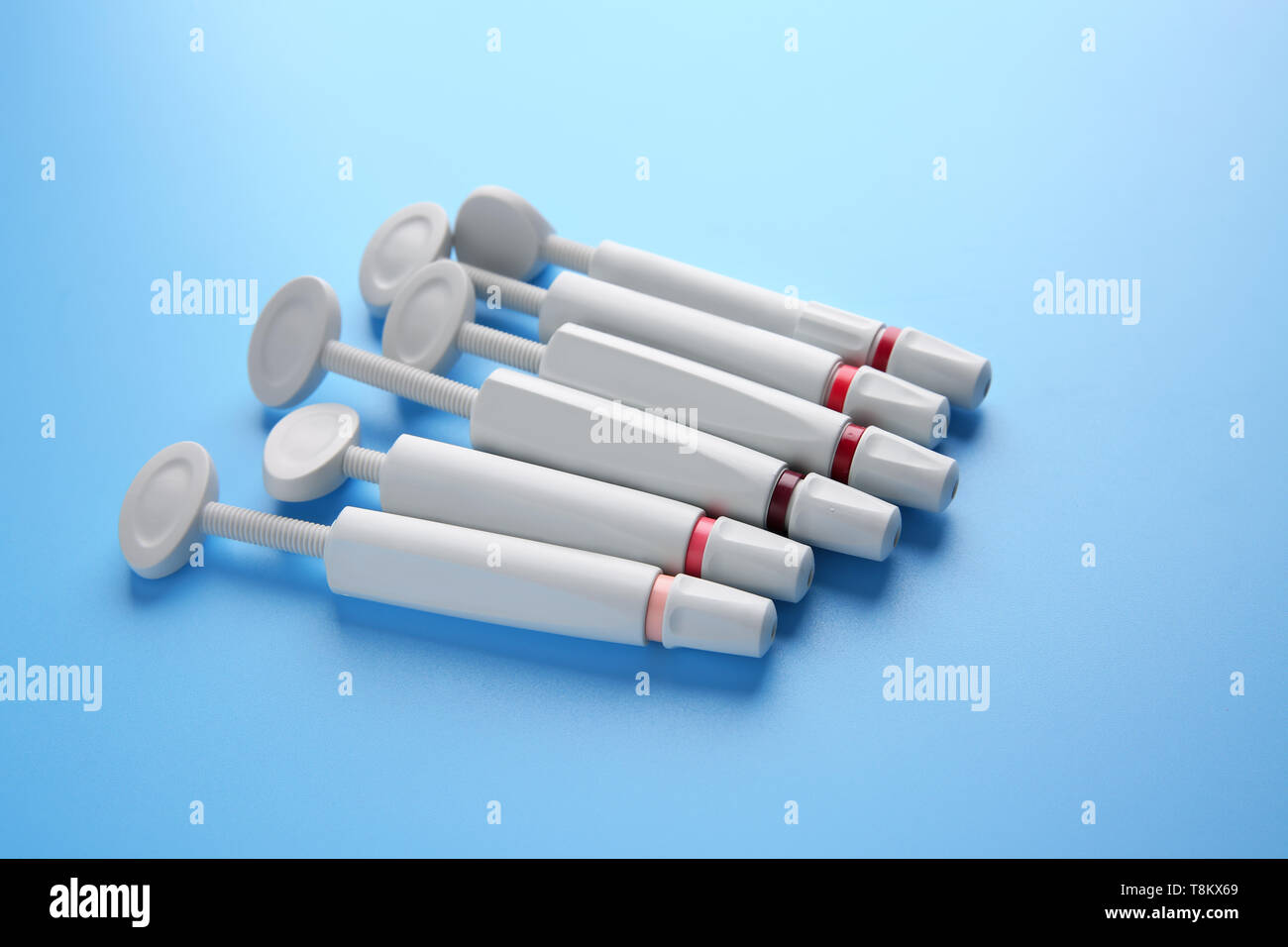 Syringes of resin luting cement on color background Stock Photo - Alamy