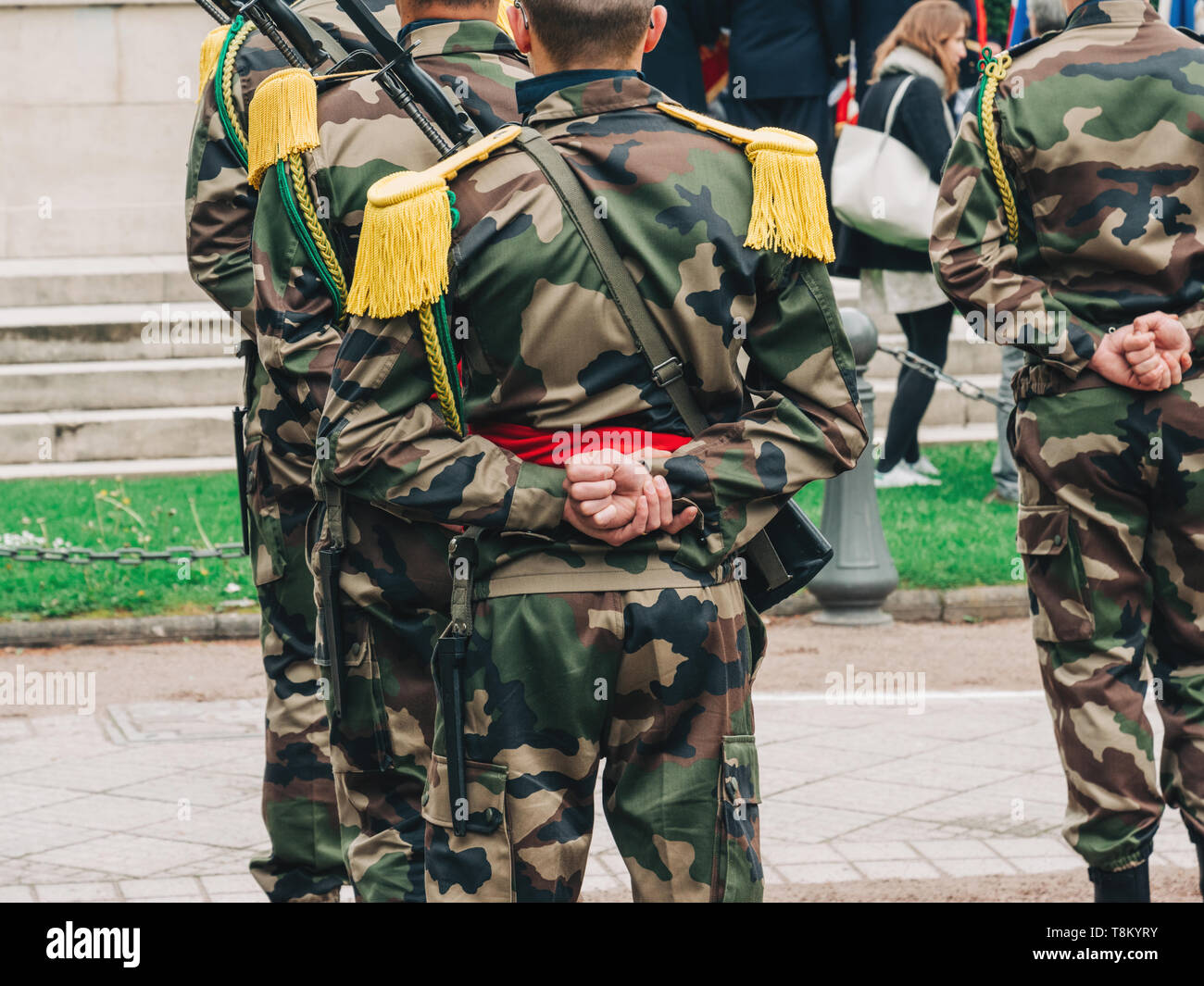 Rear view of unrecognizable group of French soldiers paying tribute at ...