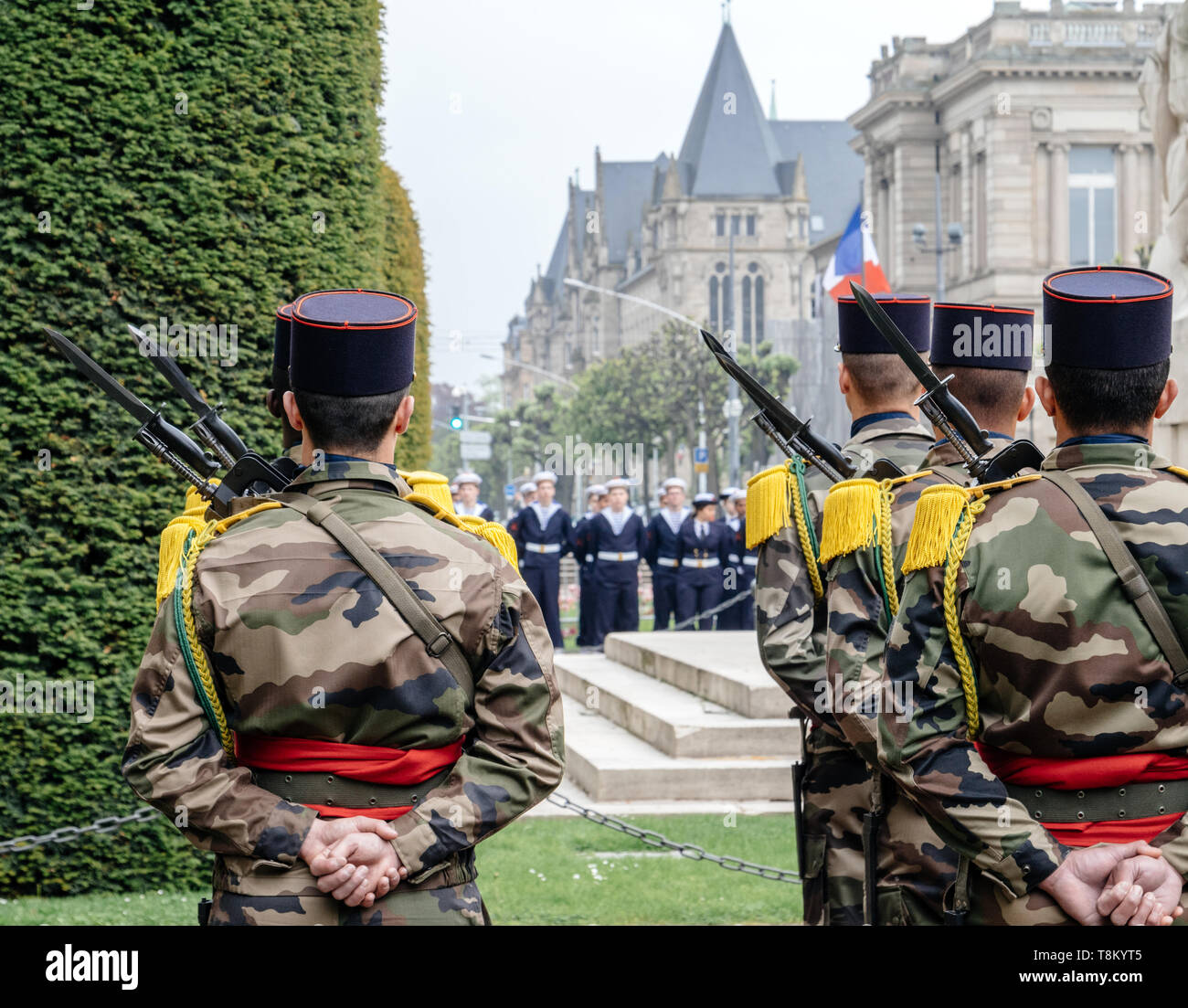 Rear view of unrecognizable French soldiers paying tribute at ceremony ...