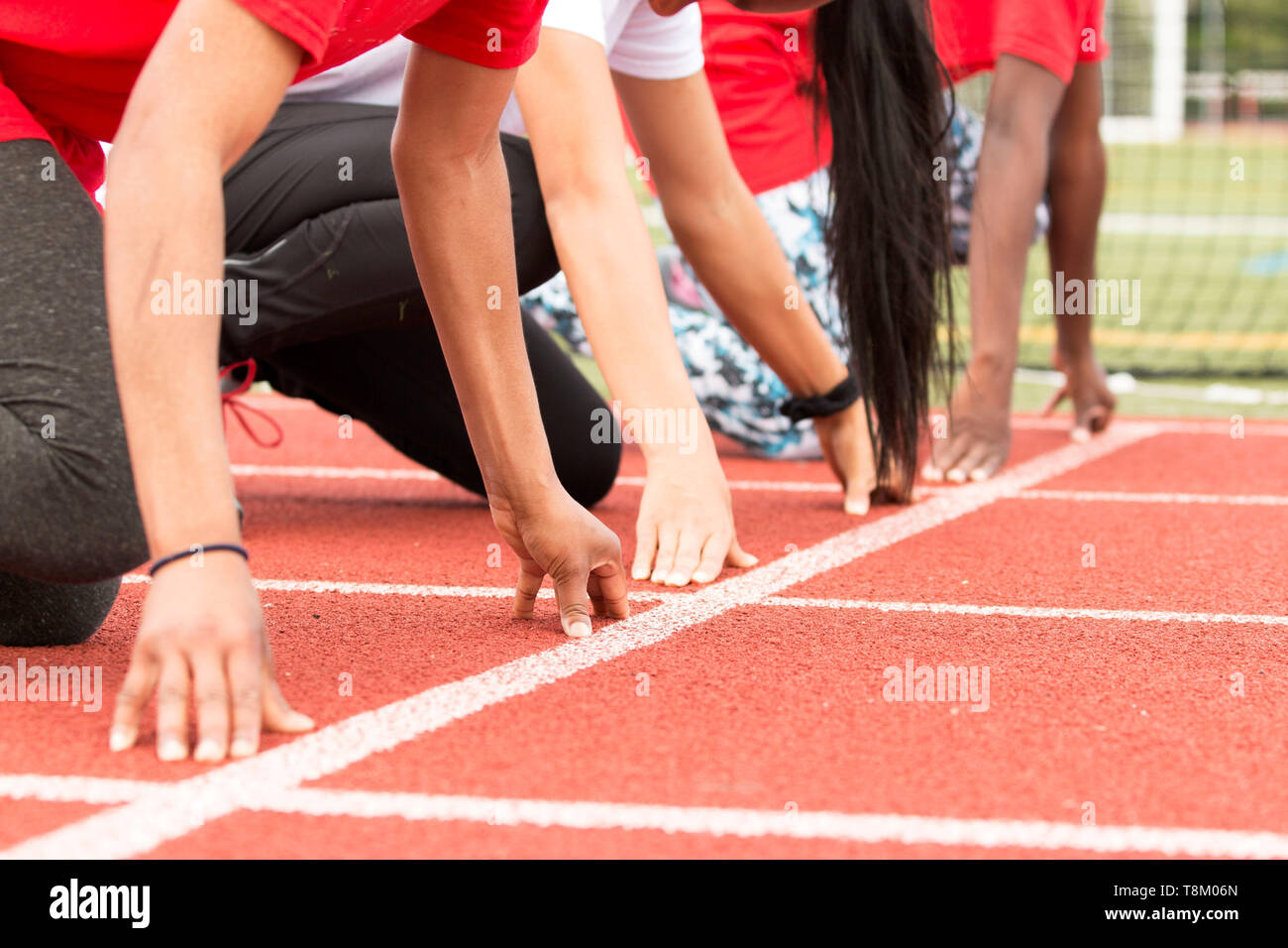 Three high school girls are ready to start a sprint race during track ...