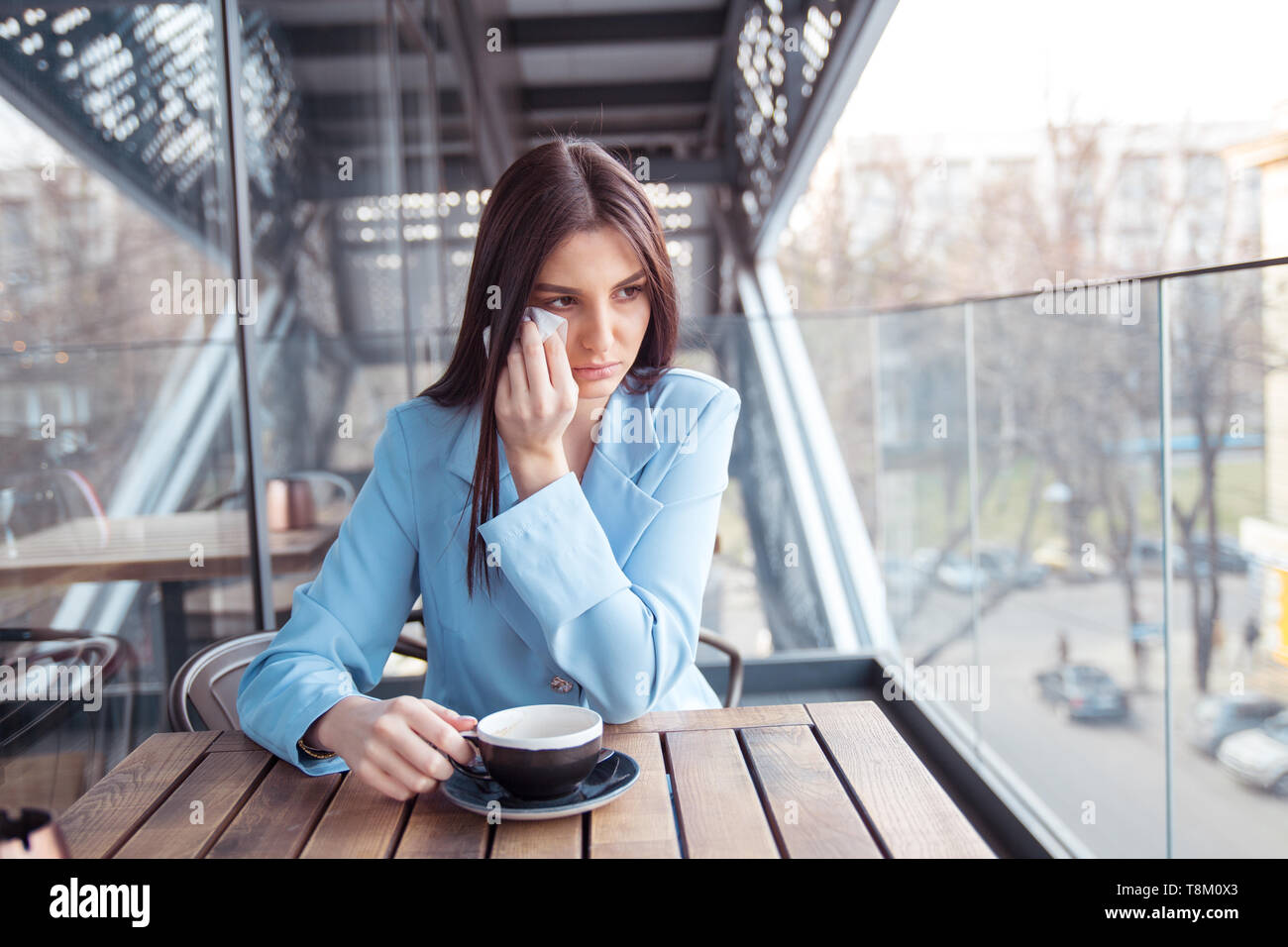 Misery, infelicity. Brunette woman girl about to cry wiping tears ...