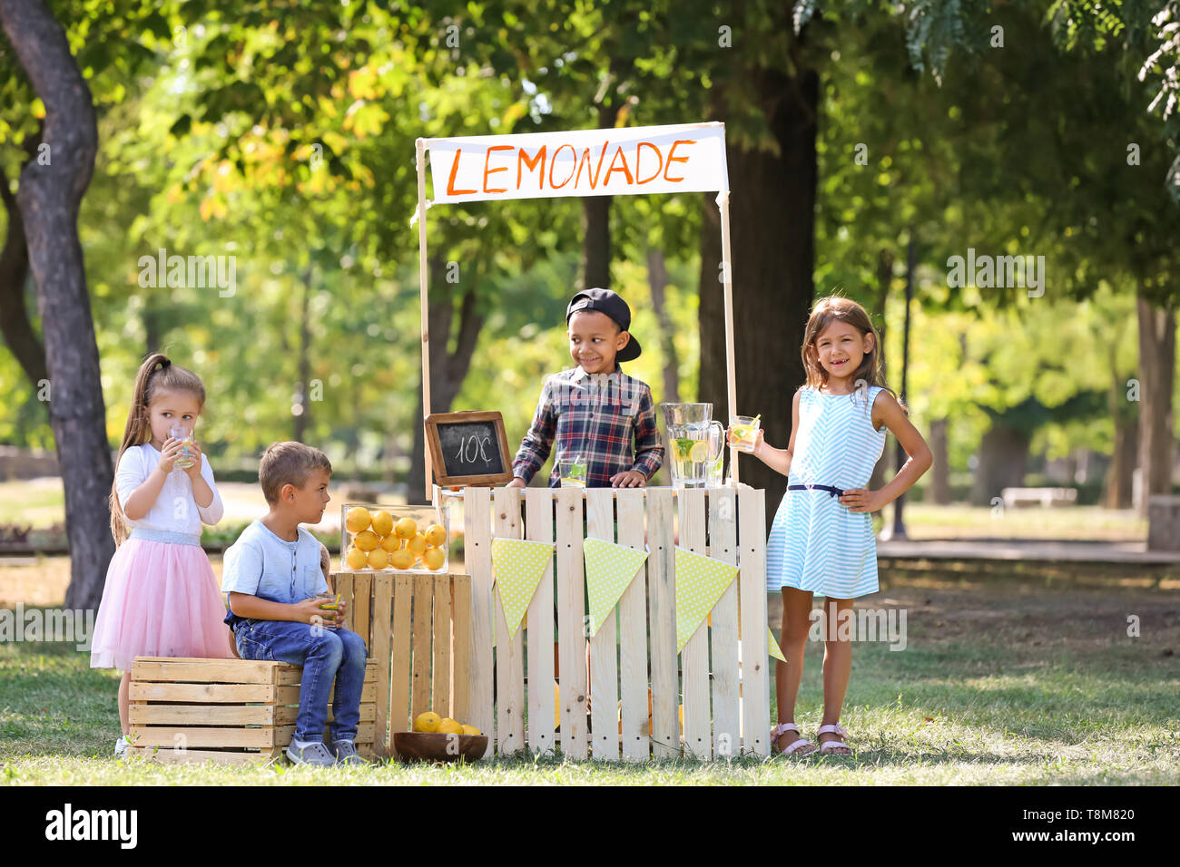 Little African-American boy selling lemonade at counter in park Stock ...