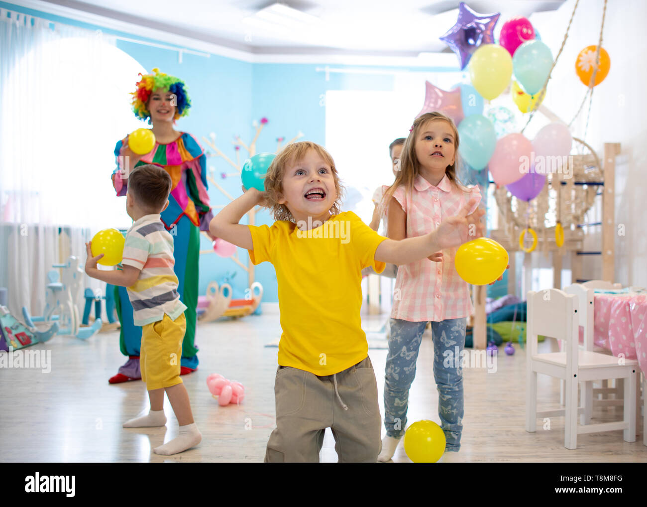 Excited kid boy playing with balloons on birthday party Stock Photo - Alamy