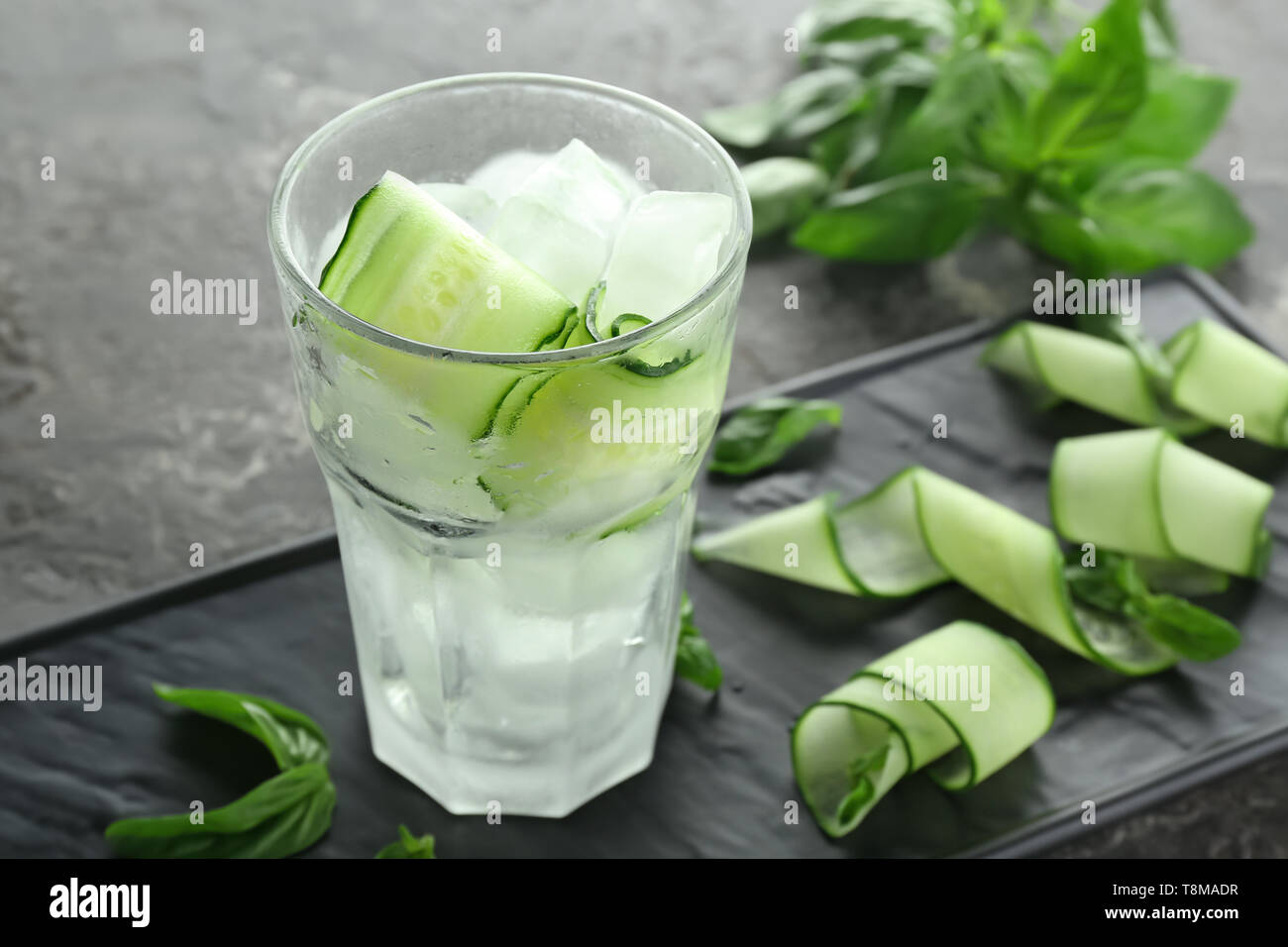 Glass of cucumber infused water with ice on table Stock Photo - Alamy