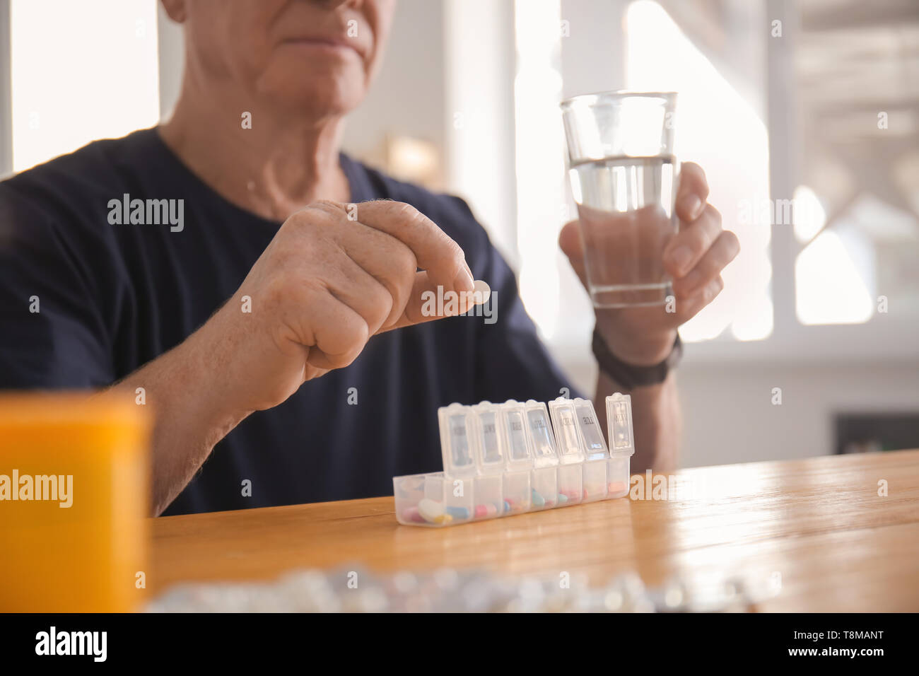 Senior man taking medicine at home Stock Photo - Alamy