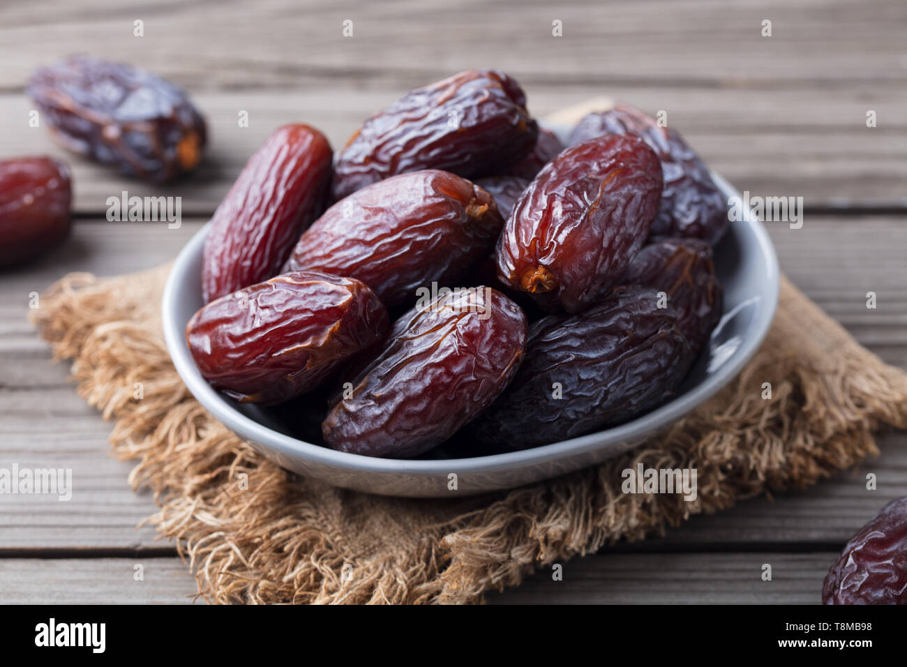 Fresh Medjool Dates in bowl. Grey wooden background. Close up Stock ...