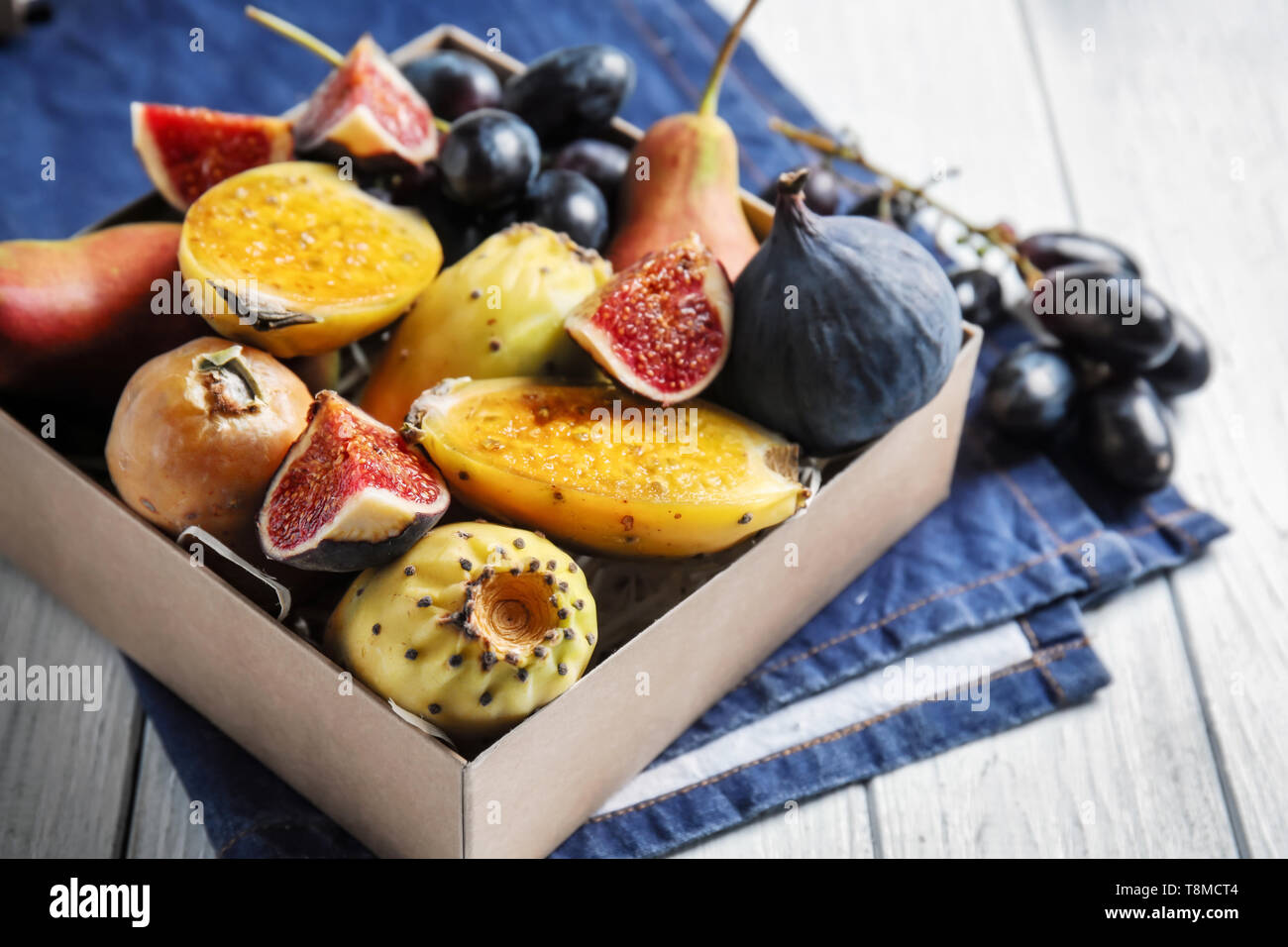 Various fresh fruits in box on wooden table Stock Photo - Alamy