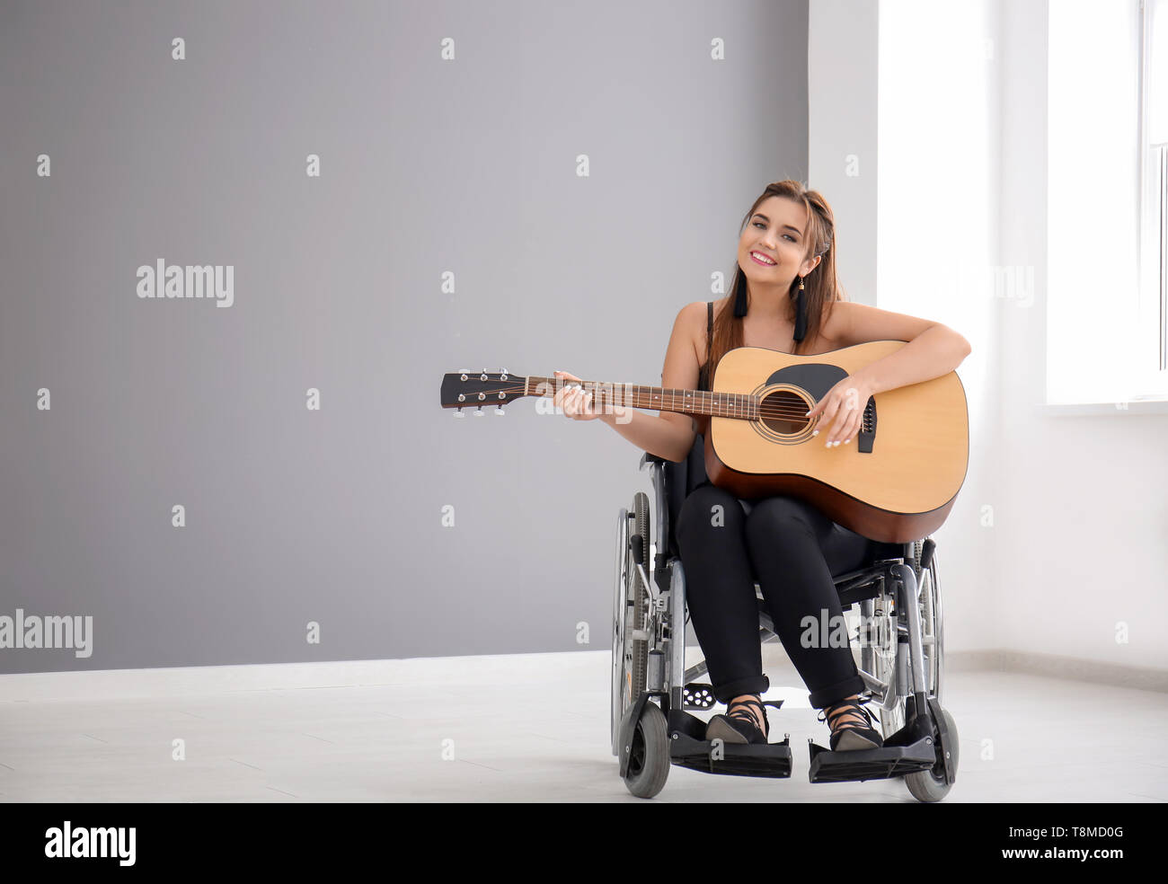 Beautiful young musician in wheelchair playing guitar indoors Stock ...