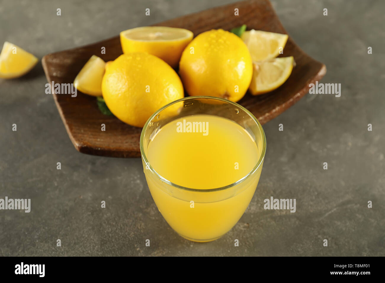 Glass of fresh lemon juice on grey table Stock Photo - Alamy
