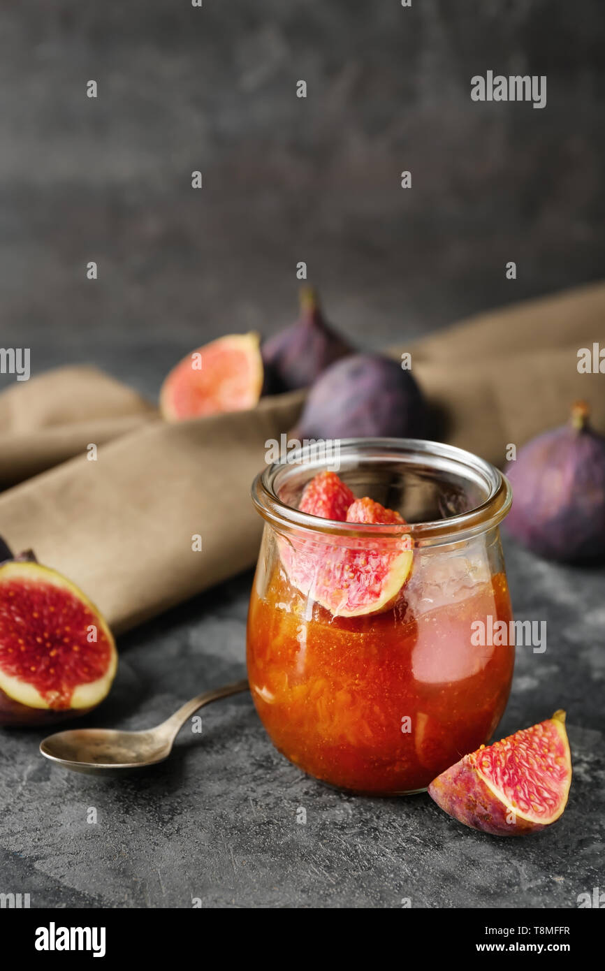 Jar of tasty fig jam on grey table Stock Photo - Alamy